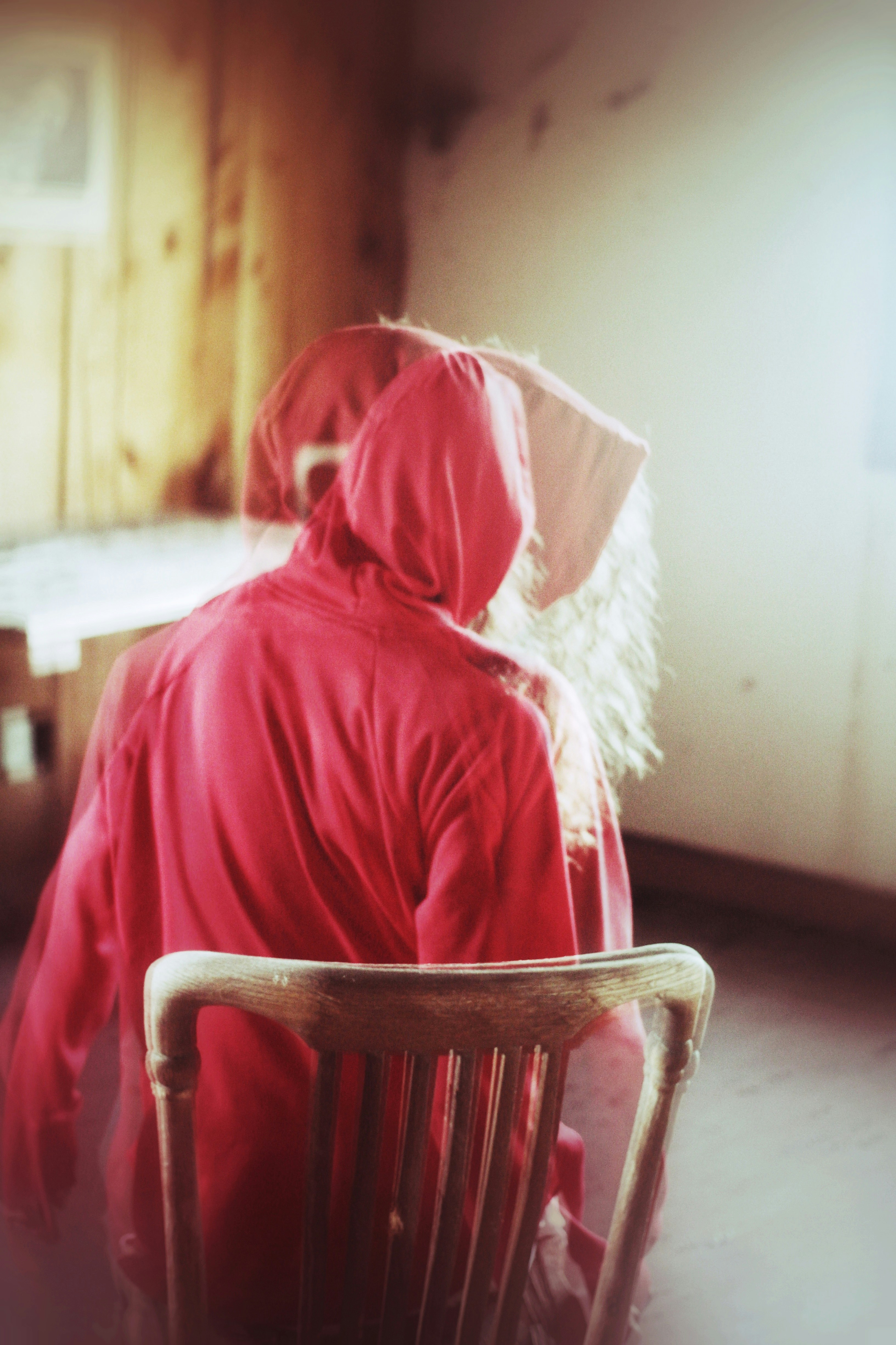 Red Hoodie Backturned in Soft Sun: Quiet Light in a Wooden Room
