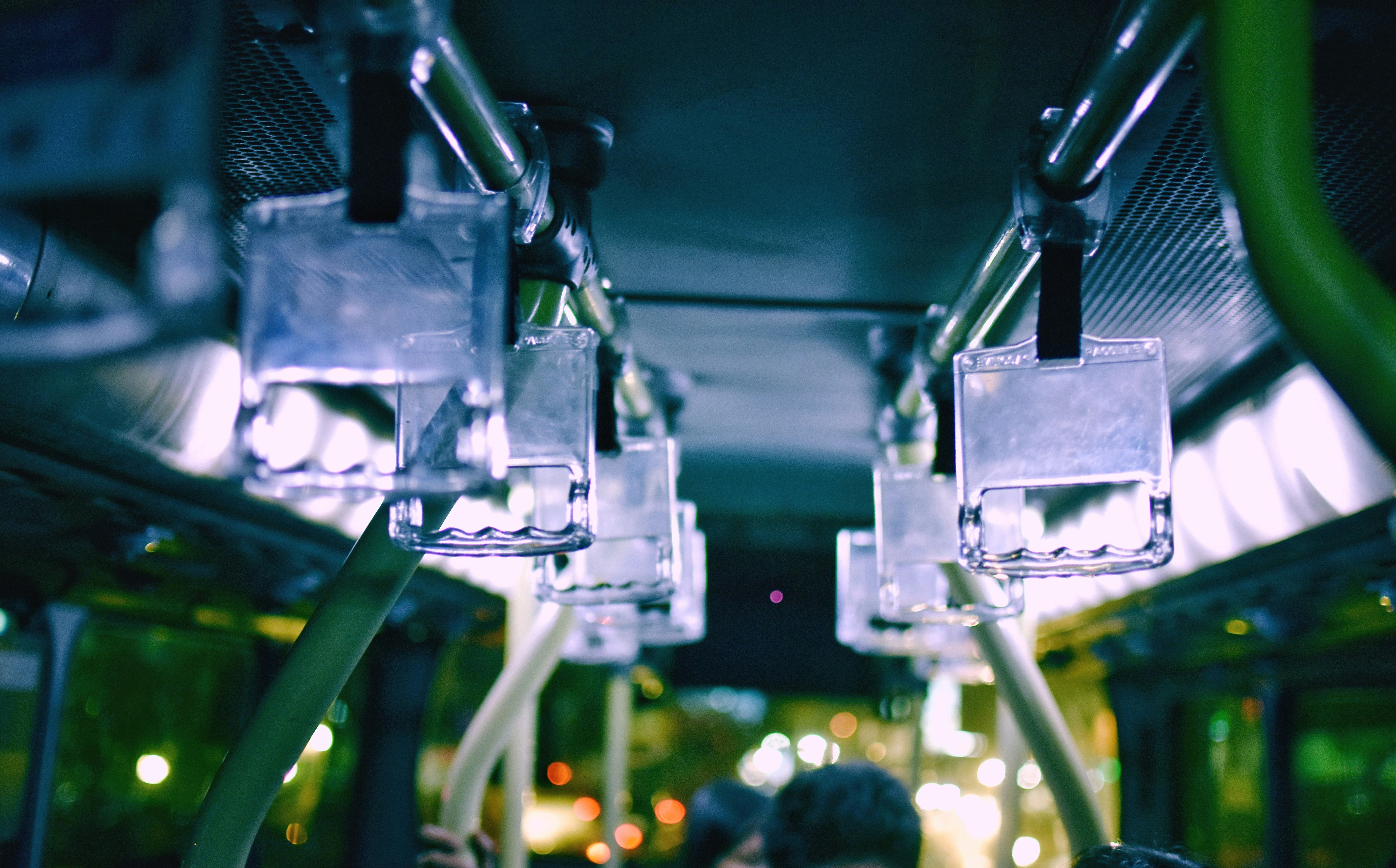 Neon-tinged Aisle: Symmetry of Overhead Handrails in a City Bus