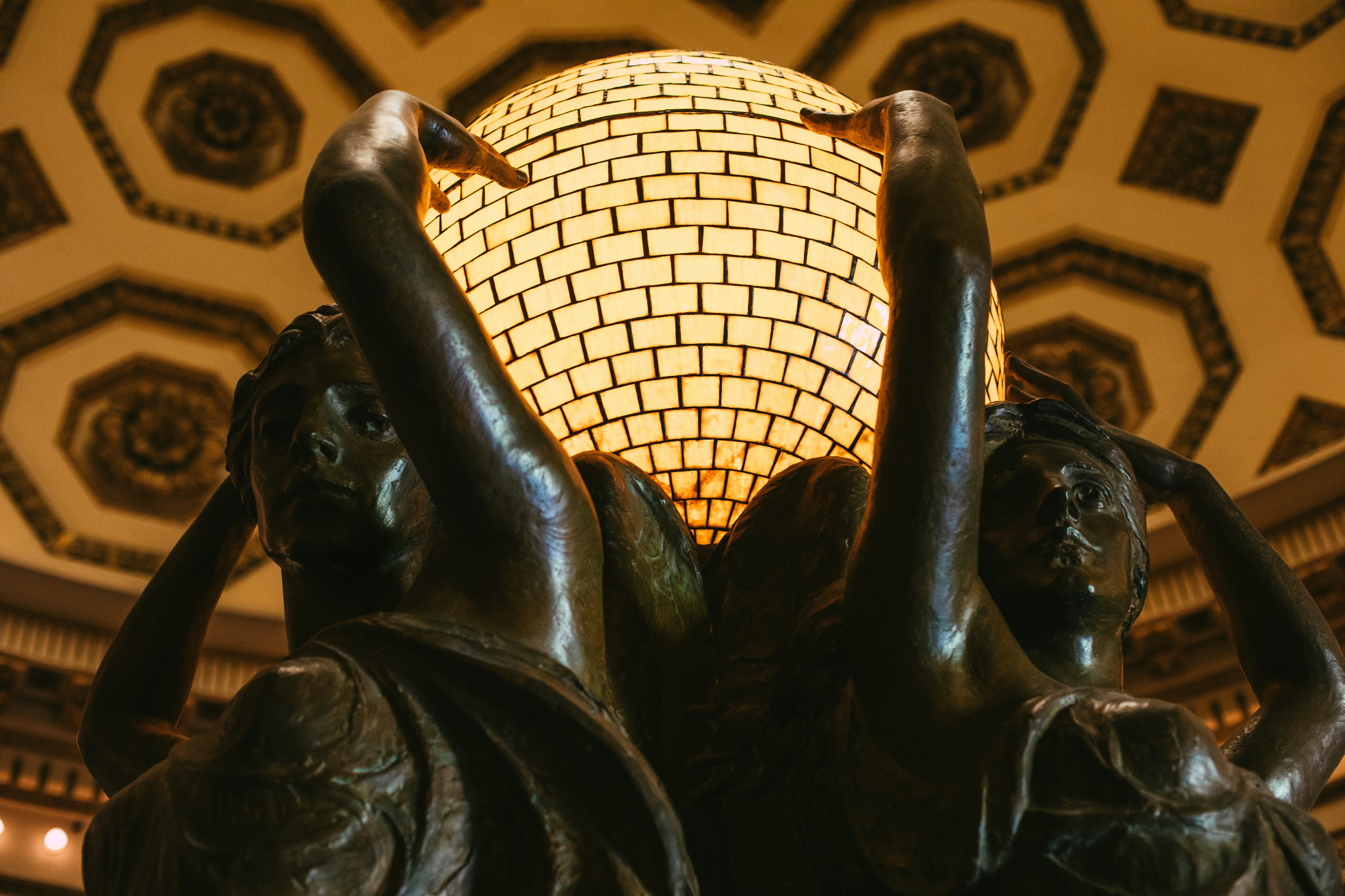 Glowing Lantern Above Silent Figures: A Timeless Interior Moment
