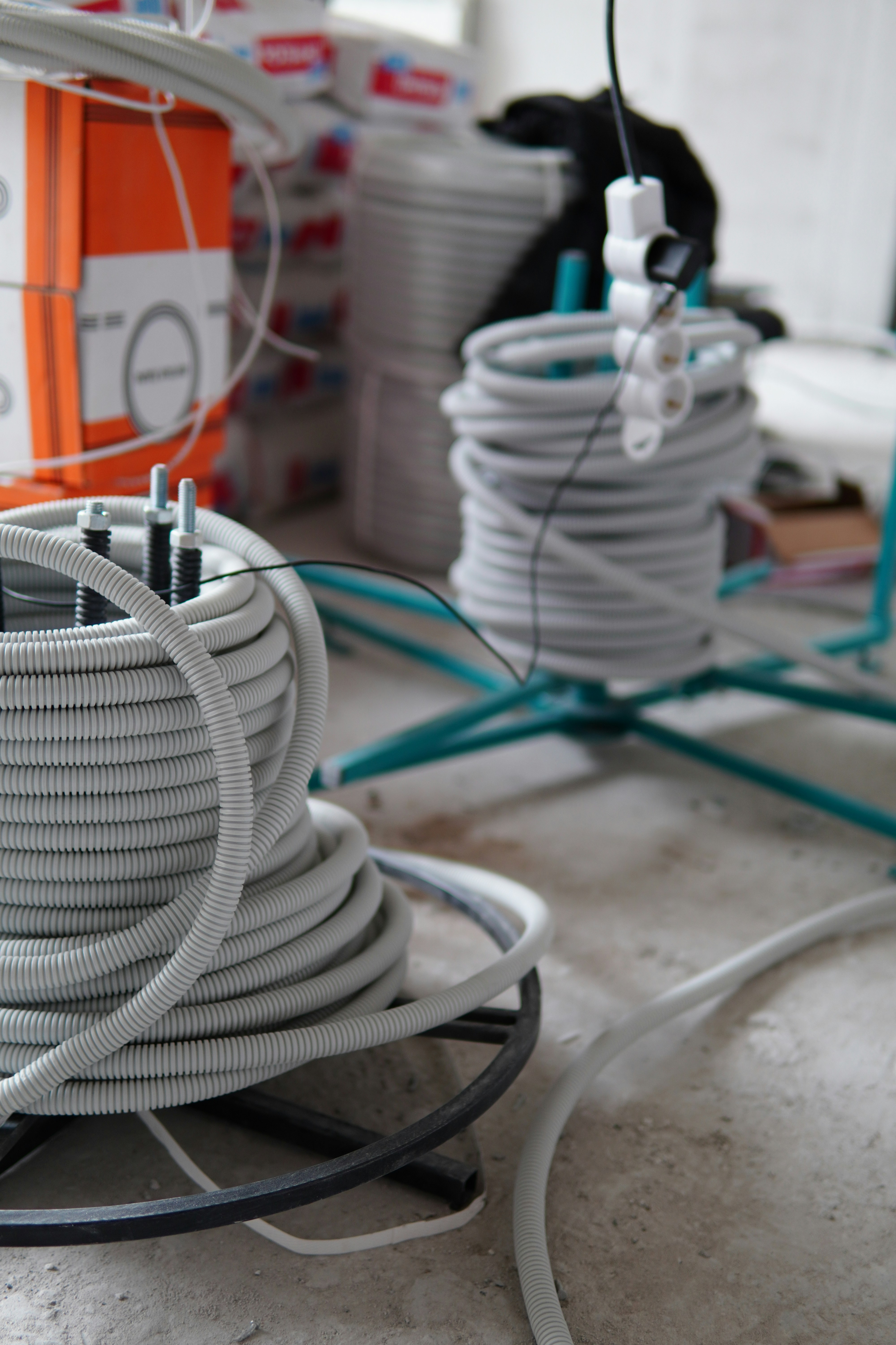 Tangled Conduits: A Close-Up of Industrial Cable Coils in a Cluttered Workshop