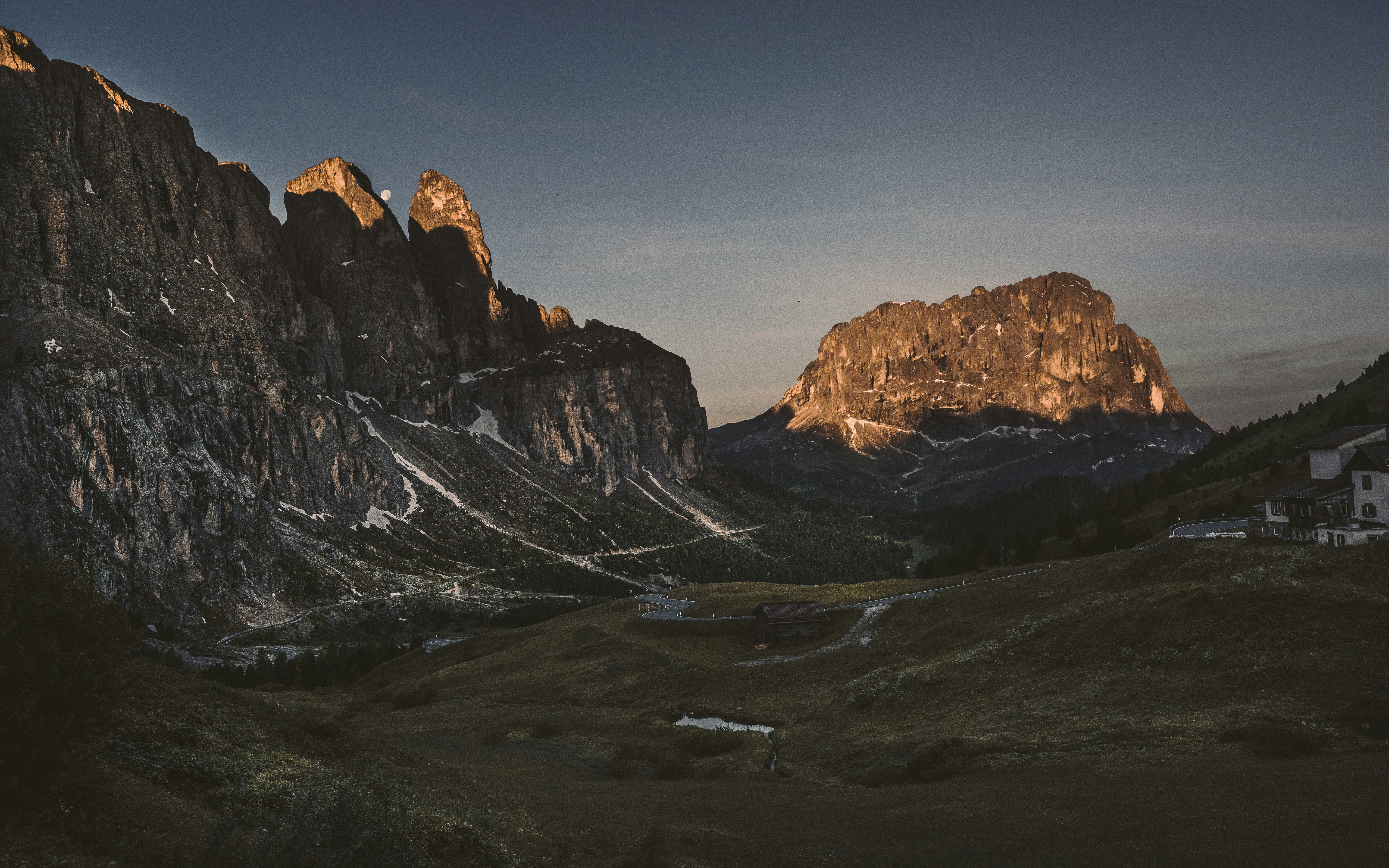 Mountain range illuminated by sunset with a clear blue sky above.