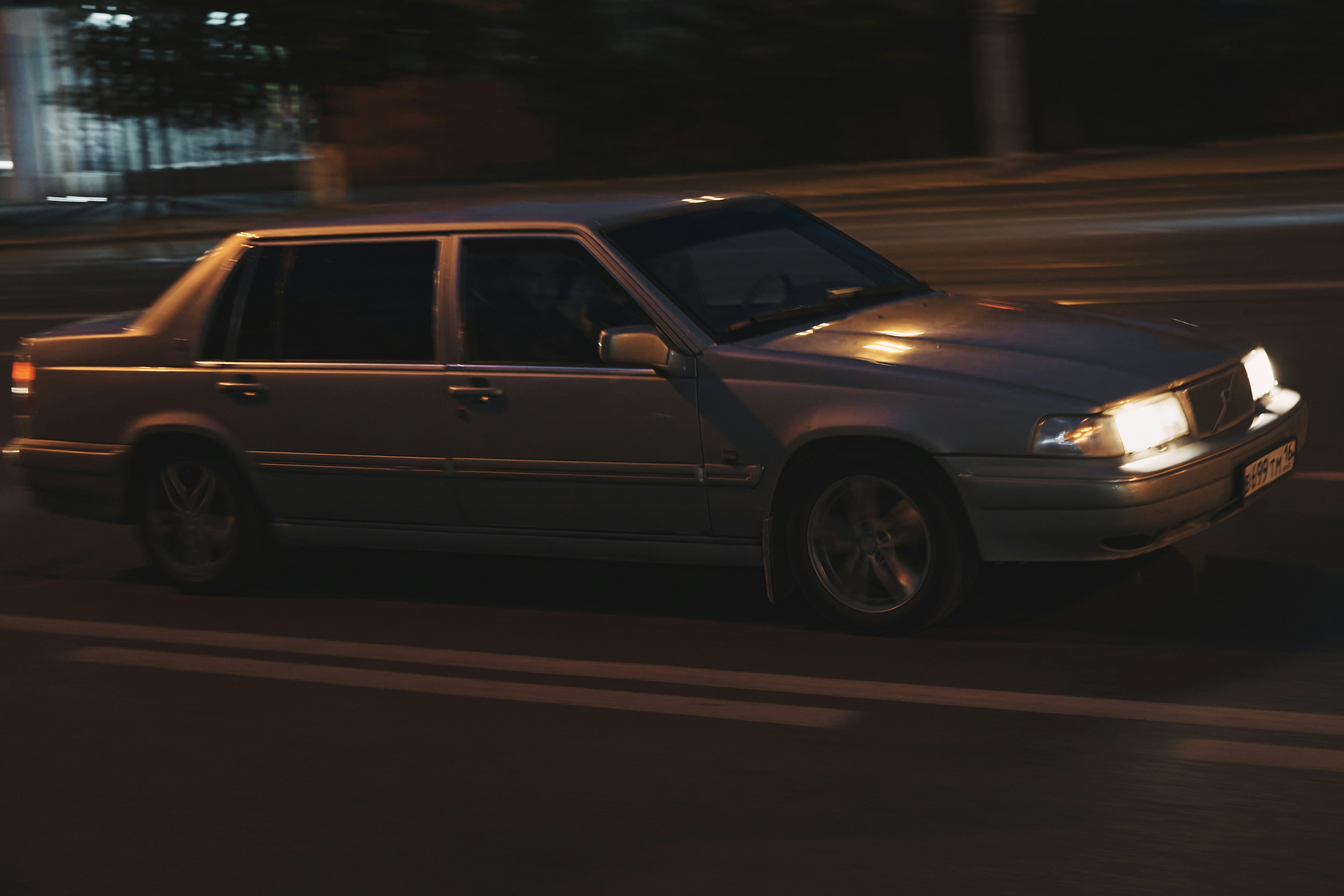 Night-Drive Blur: A Classic Sedan Traversing Neon-Hazed Streets