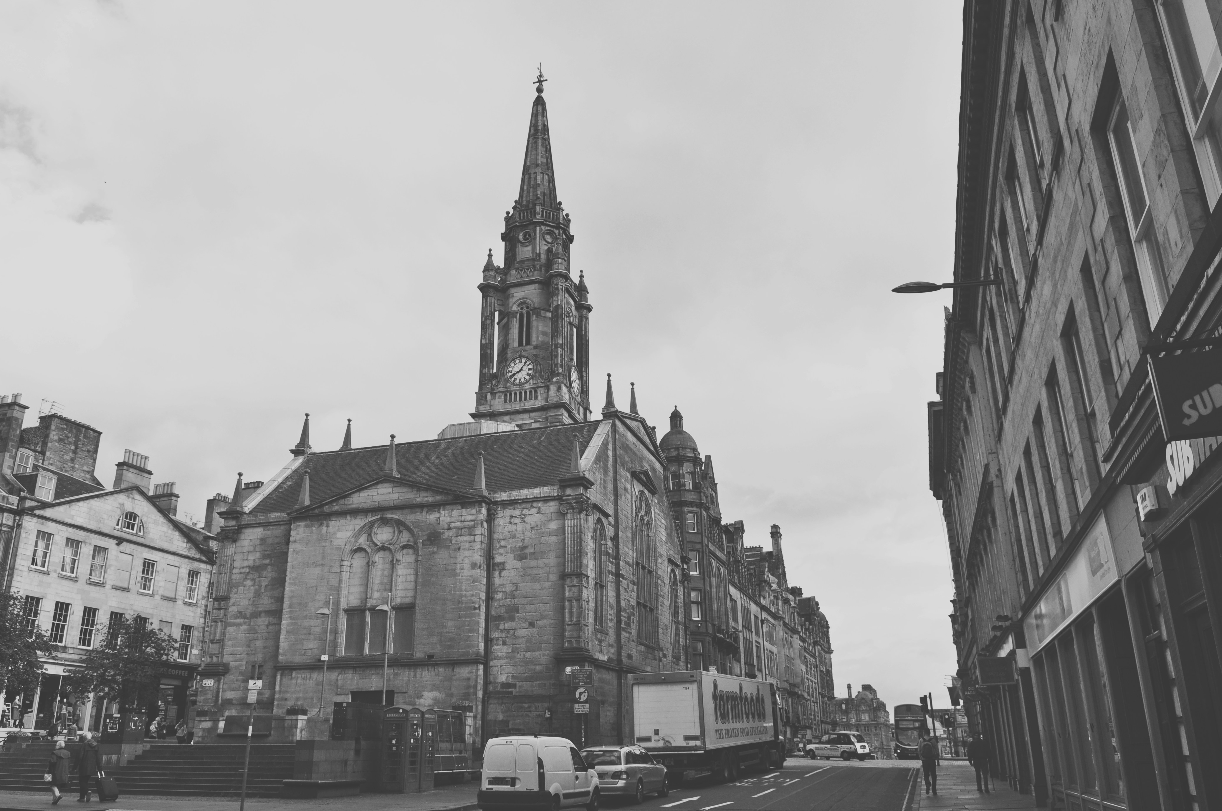 Historic church tower rising above the urban landscape, surrounded by modern buildings and bustling streets.