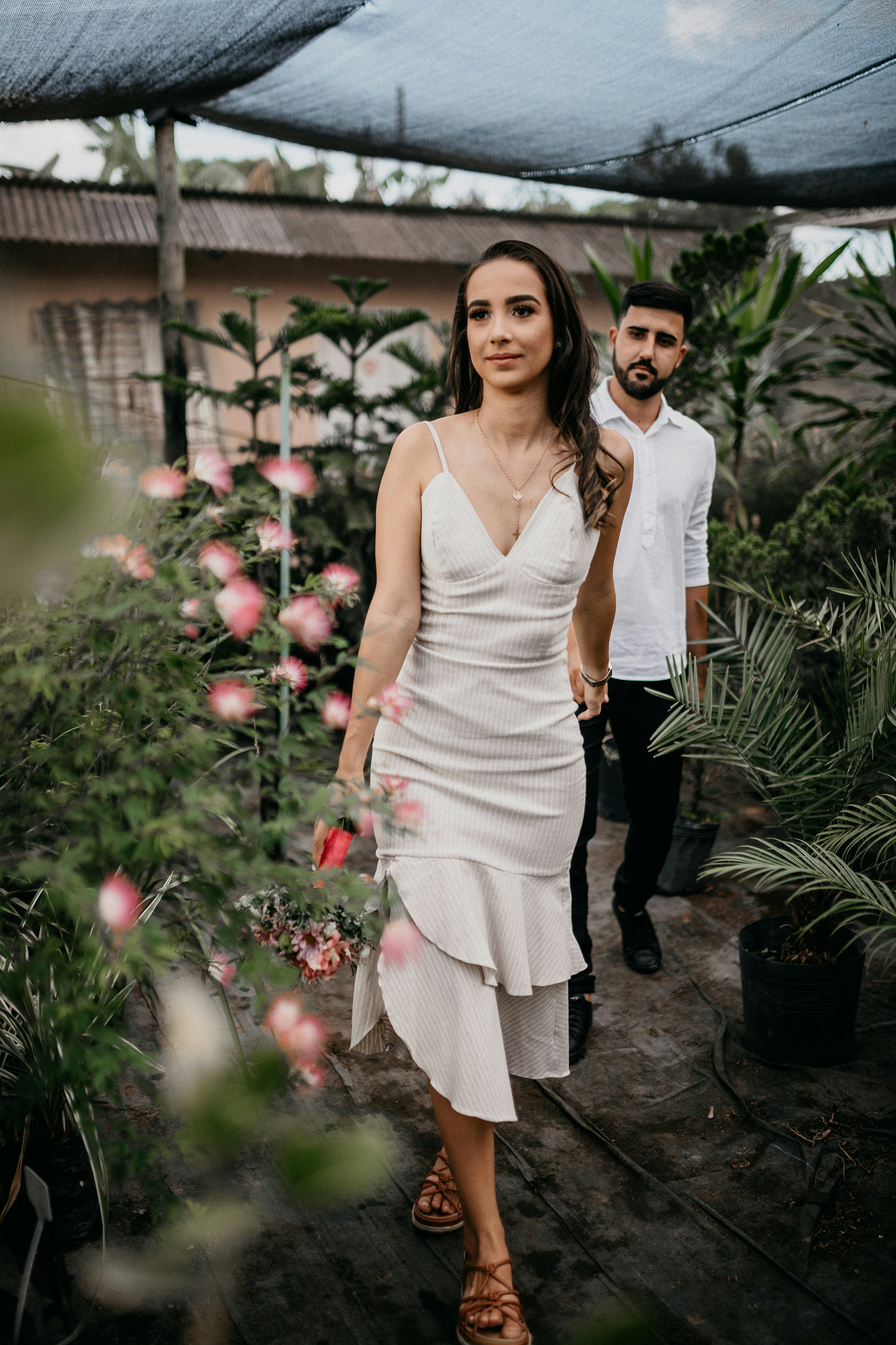 woman in white sleeveless dress standing beside man in white suit