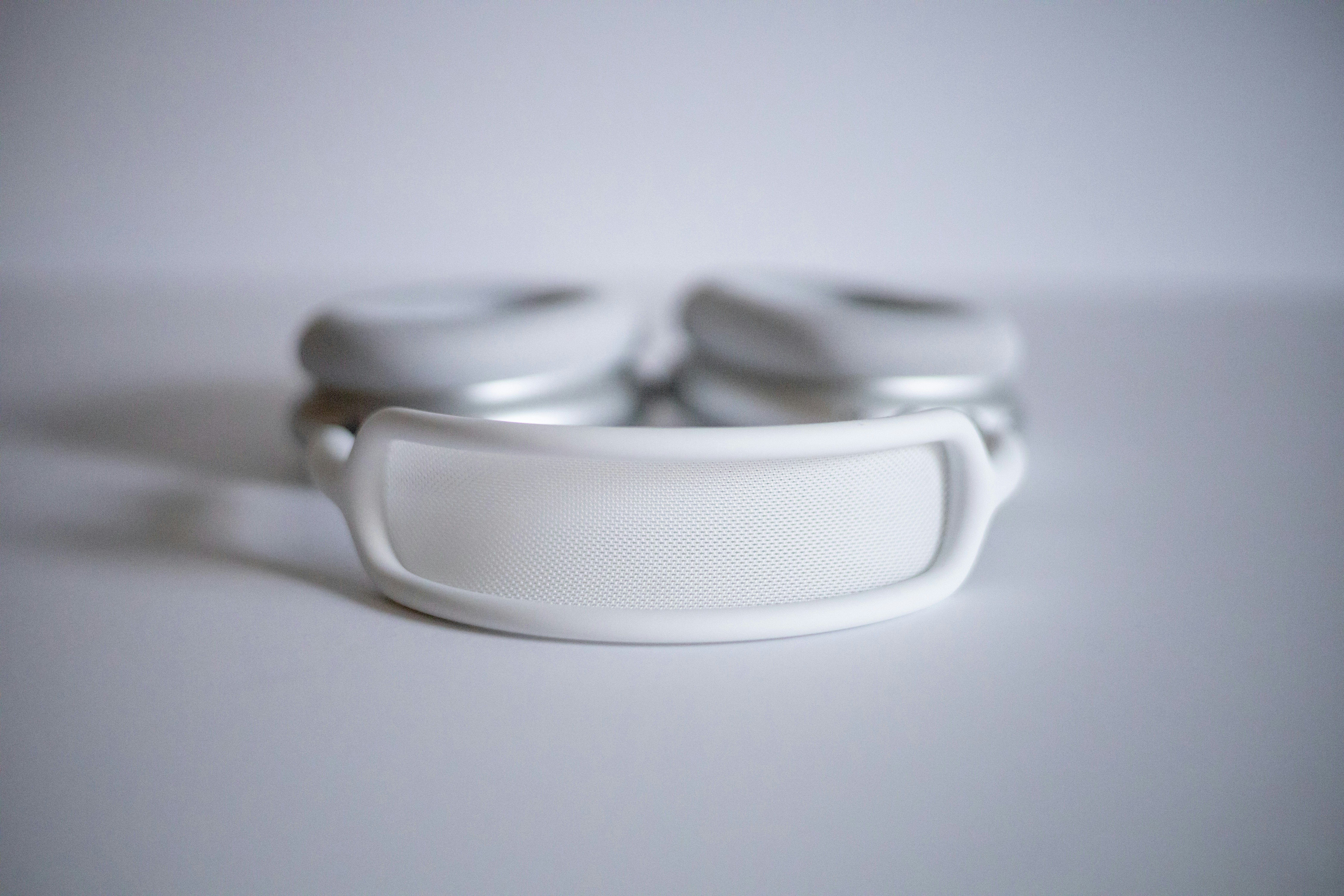 White headphones resting on a smooth surface, showcasing their sleek design and modern aesthetic.