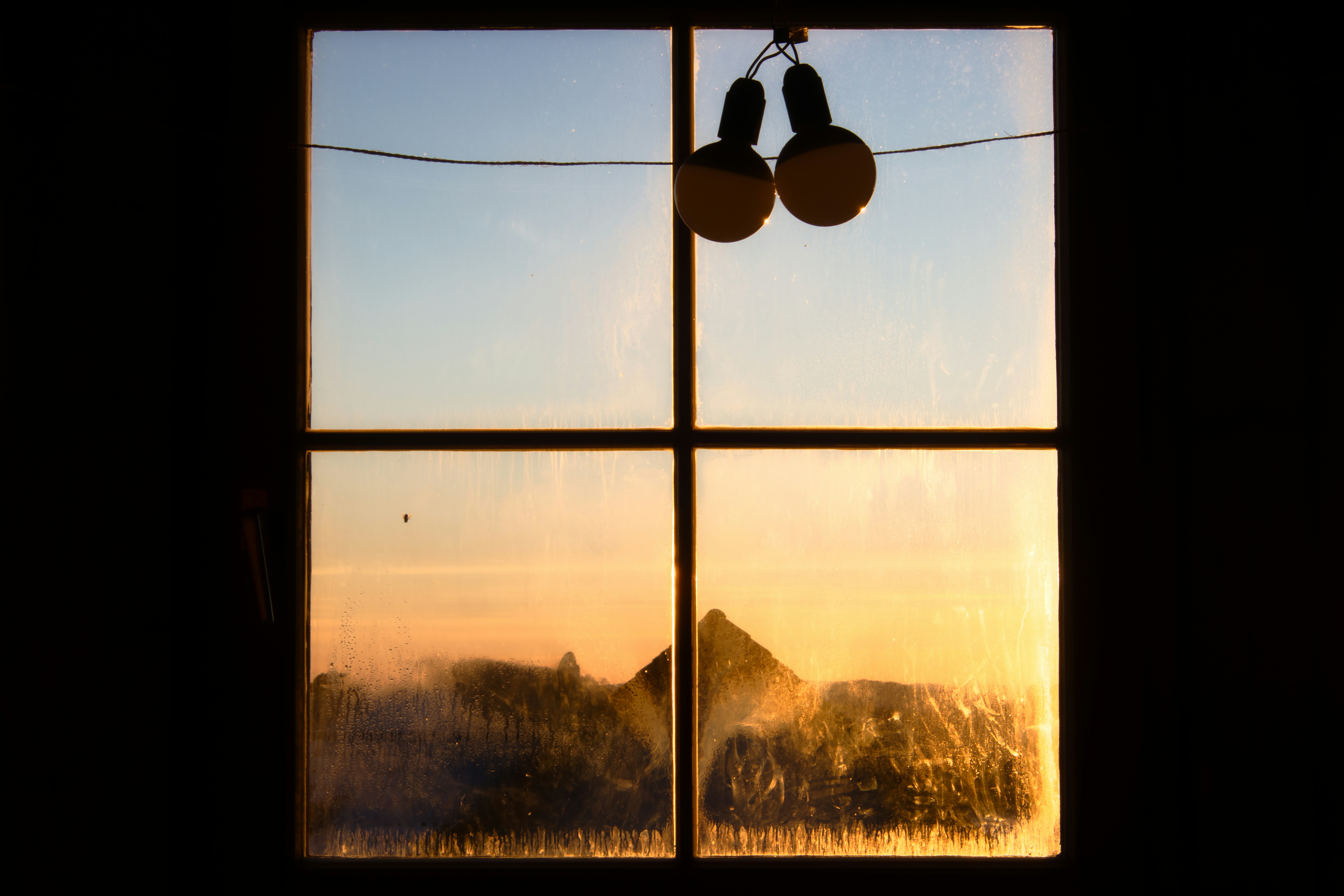 Horizon in Four Panels: Pendant Lights Framing Sunset