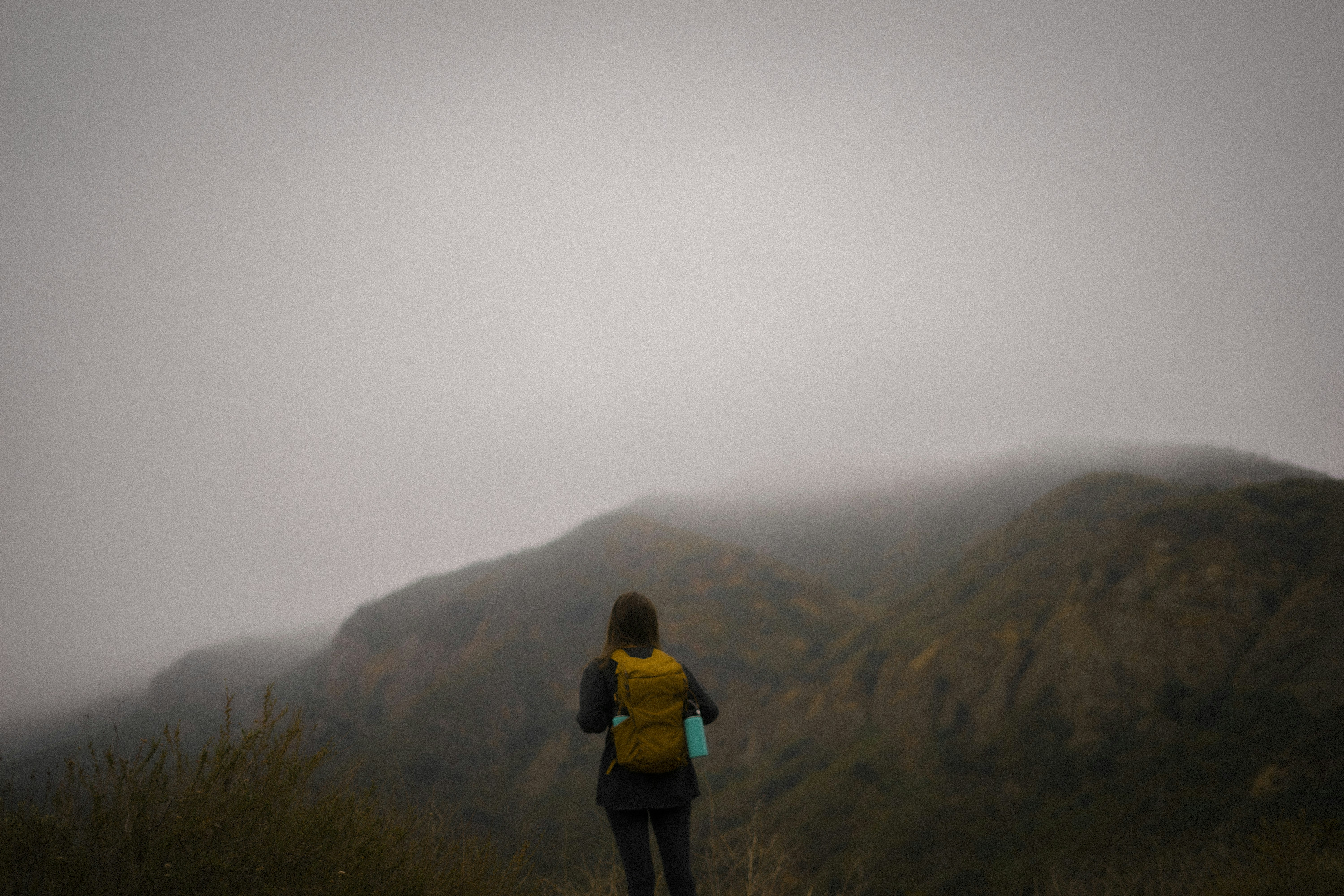Horizon Bound: A solitary hiker against misty cliffs