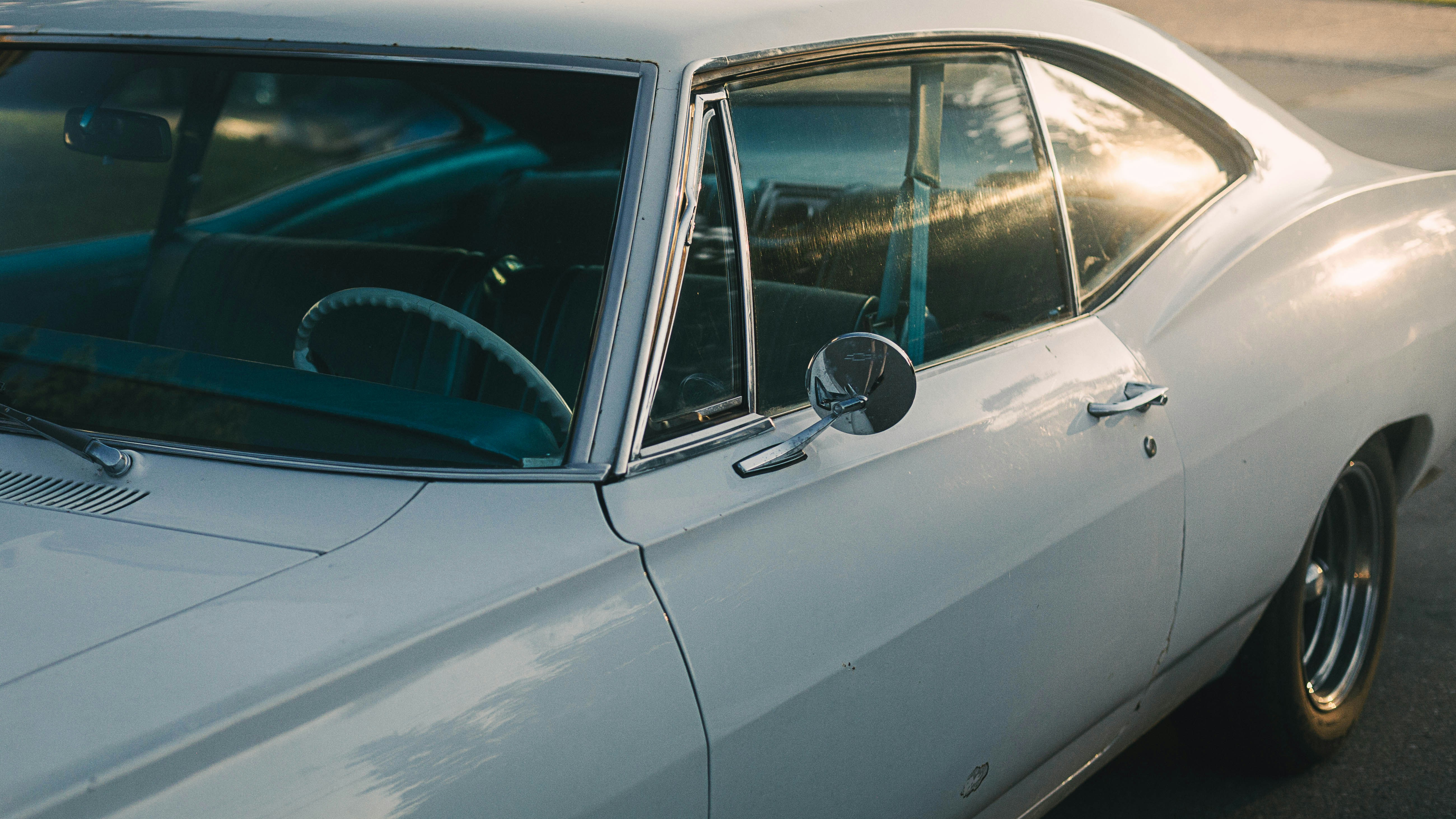 Classic white Chevy parked on a street during sunset, reflecting warm light.