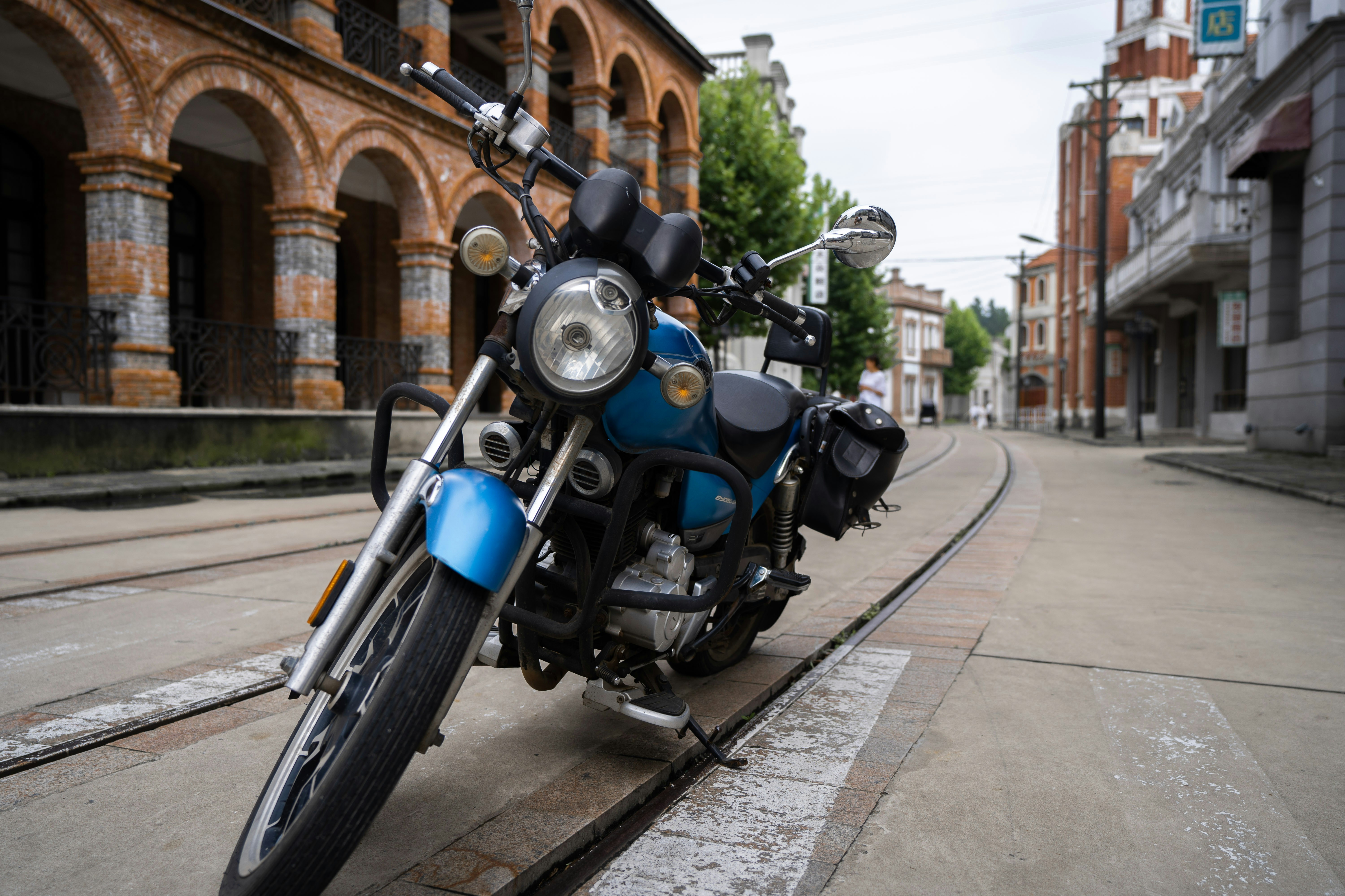 blue and black motorcycle parked on sidewalk during daytime