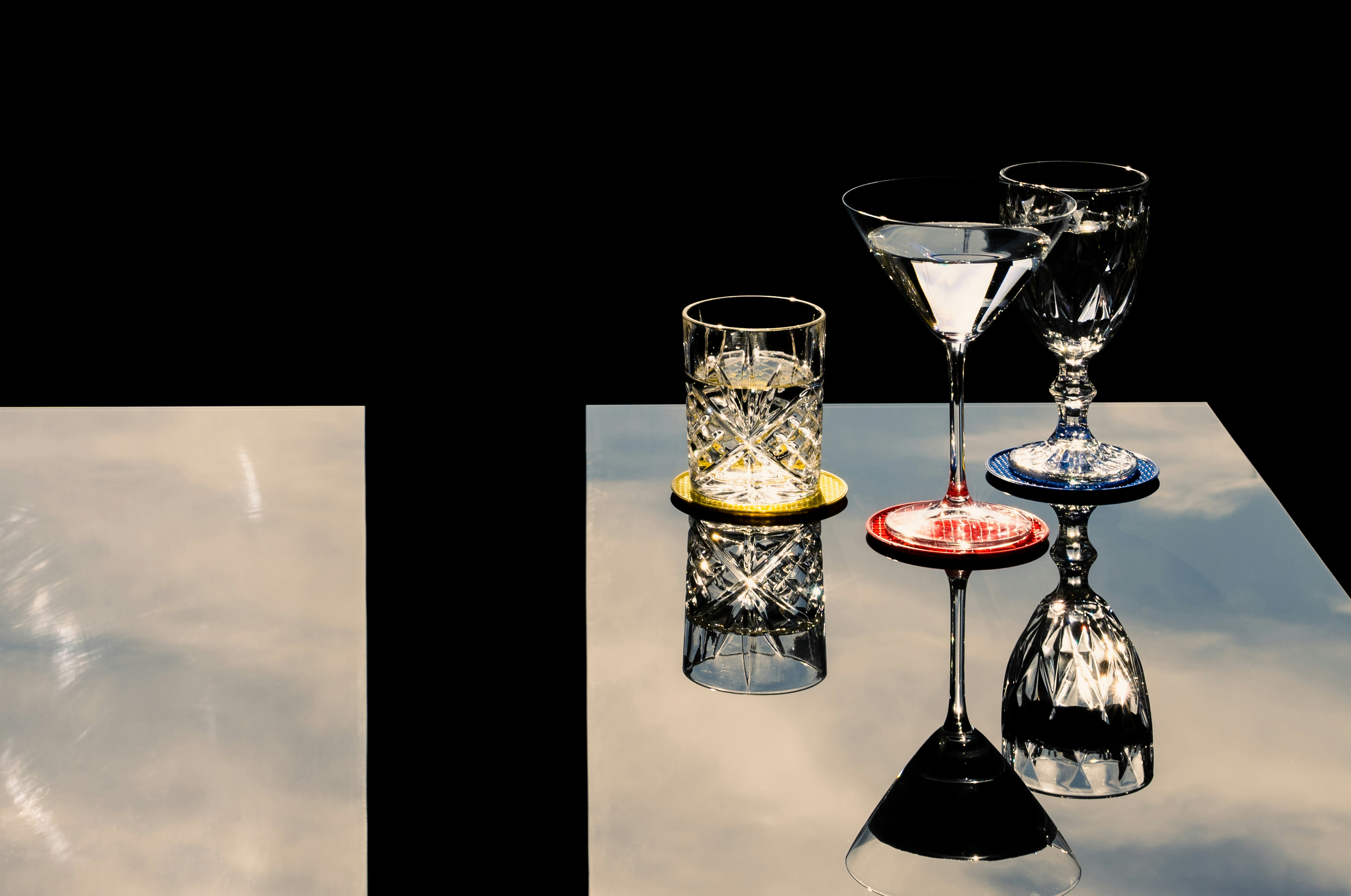 Reflected Glass Geometry: A Trio of Stemware on a Mirrored Table