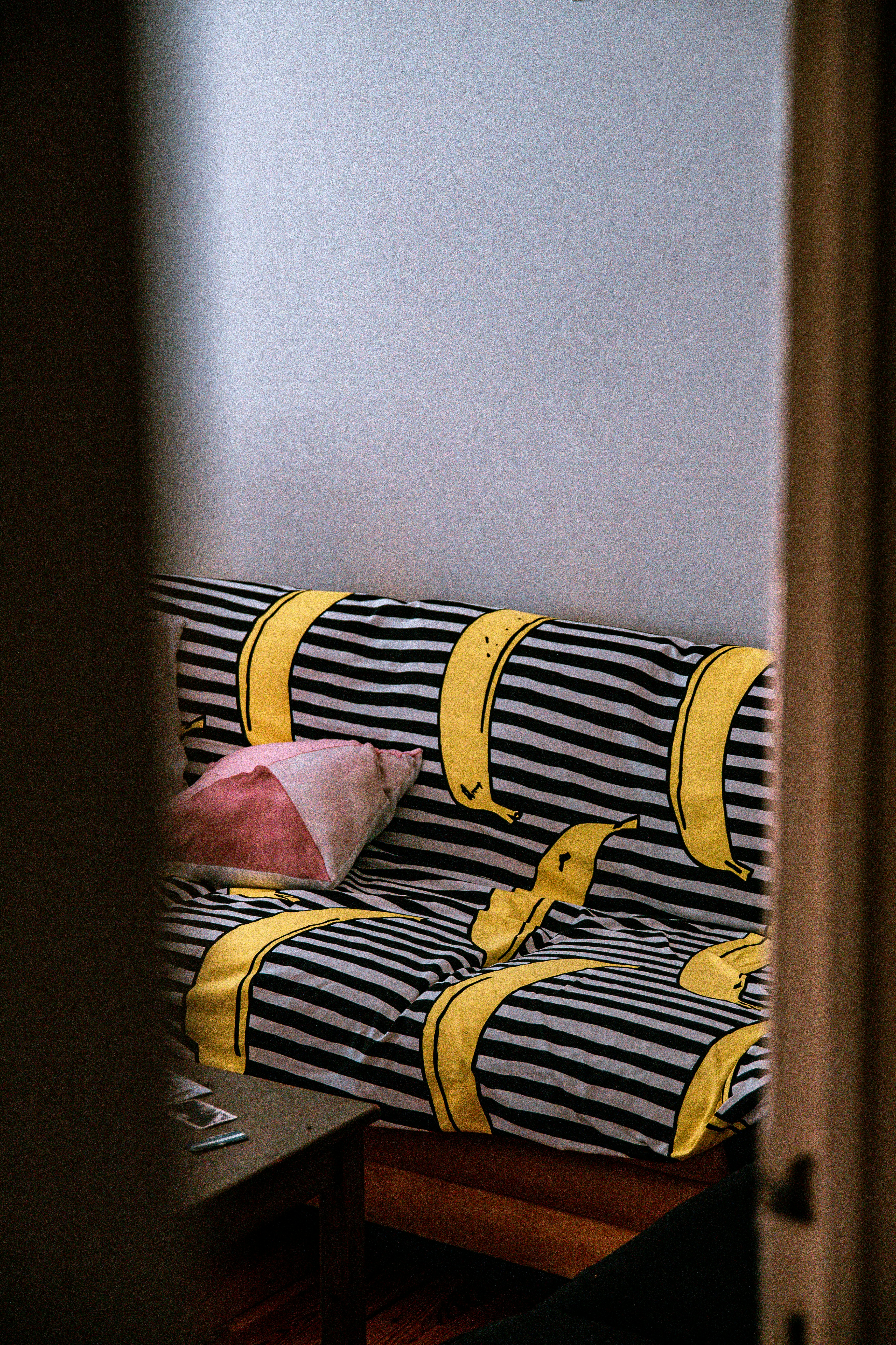 Banana-Striped Sofa and Pink Pillow: A Quiet Living Room Moment