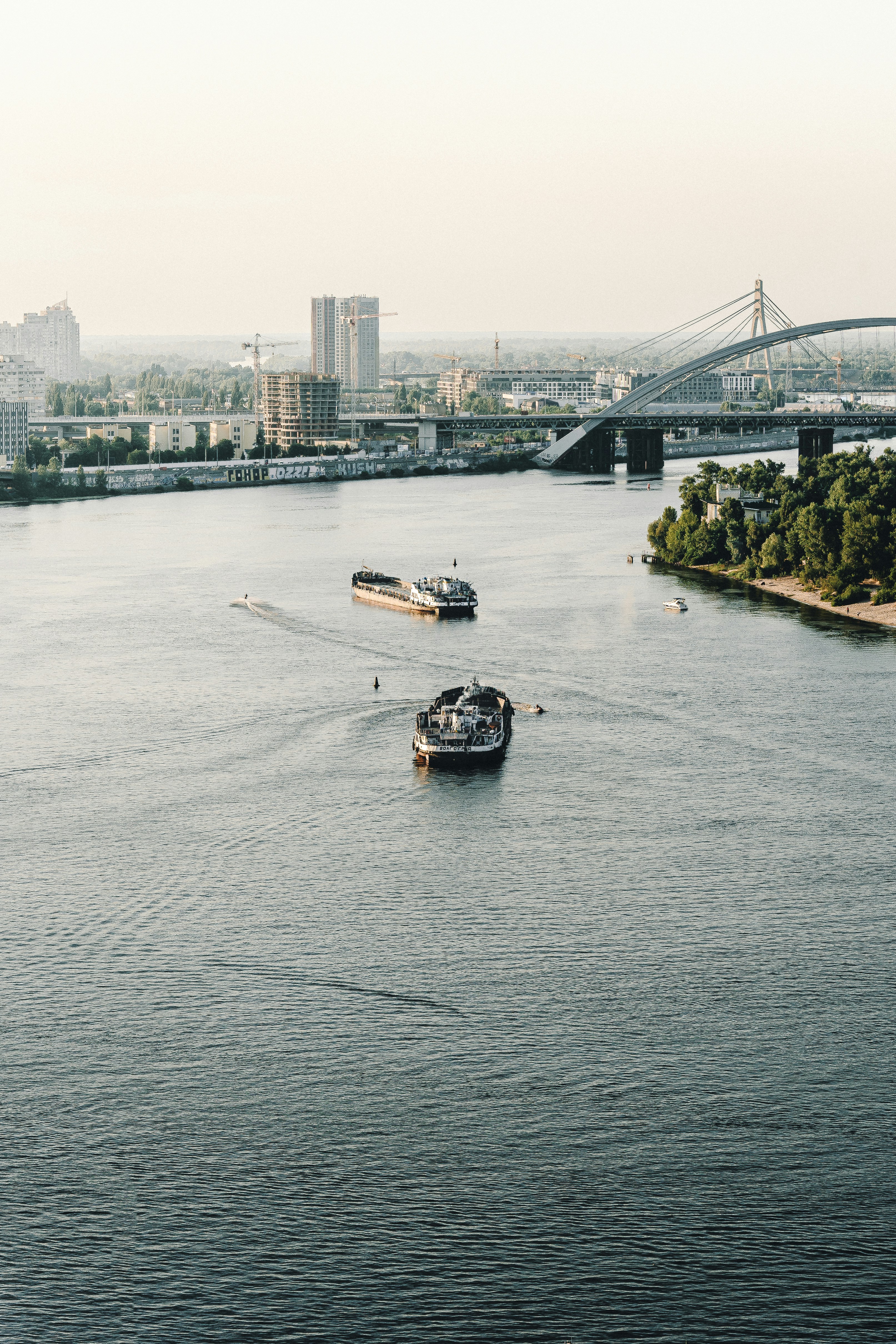 Two Barges, One Flow: A Quiet River Crossing Under a Modern Arch