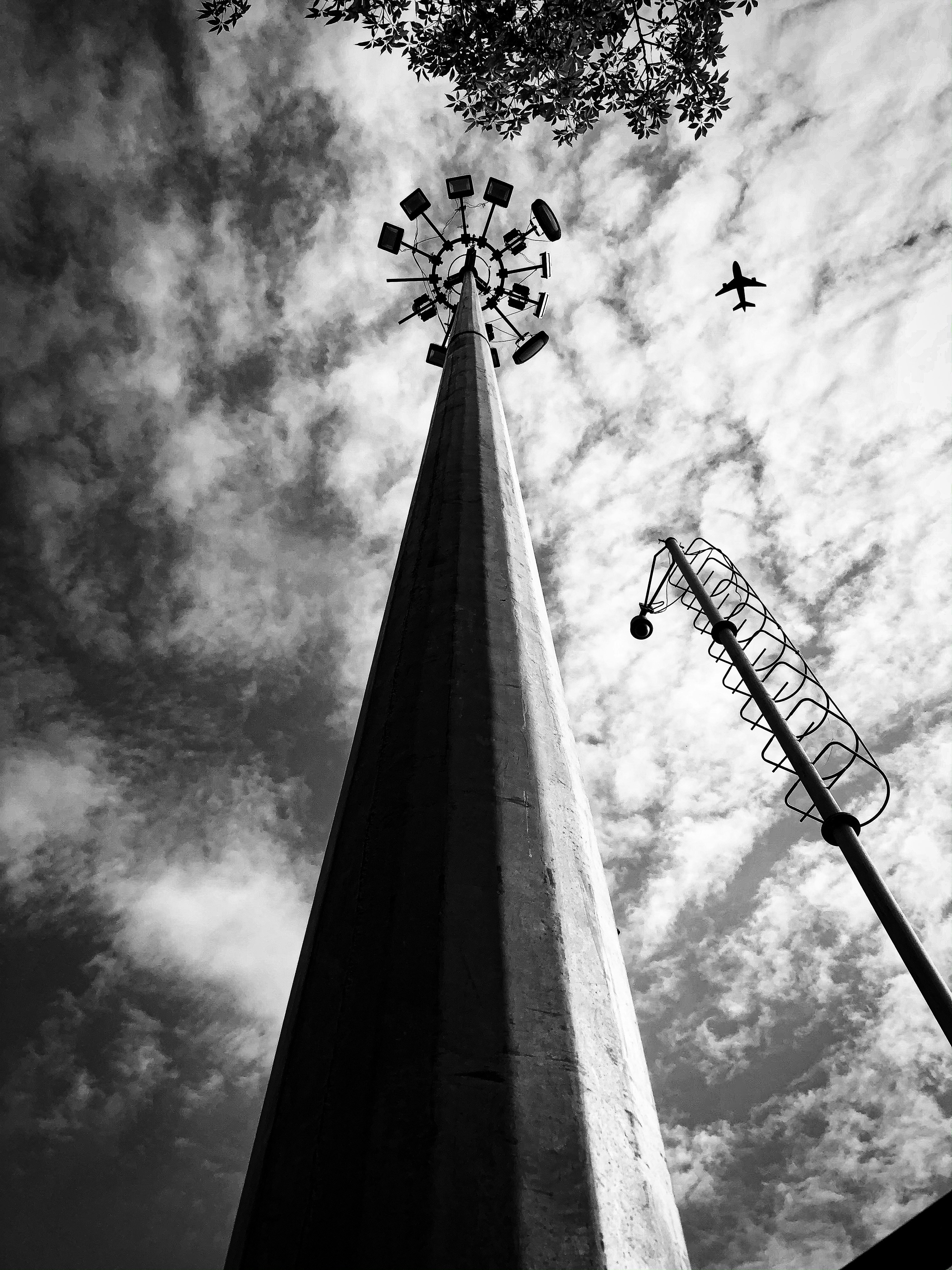 Obelisk Under a Sky of Clouds and a Passing Plane