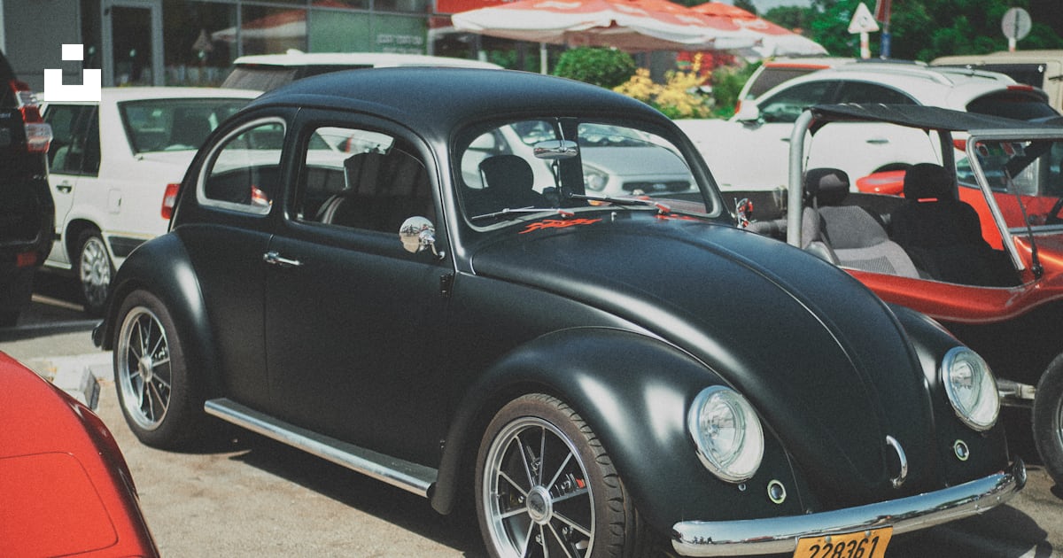 Black Volkswagen Beetle Parked On Gray Concrete Floor During Daytime