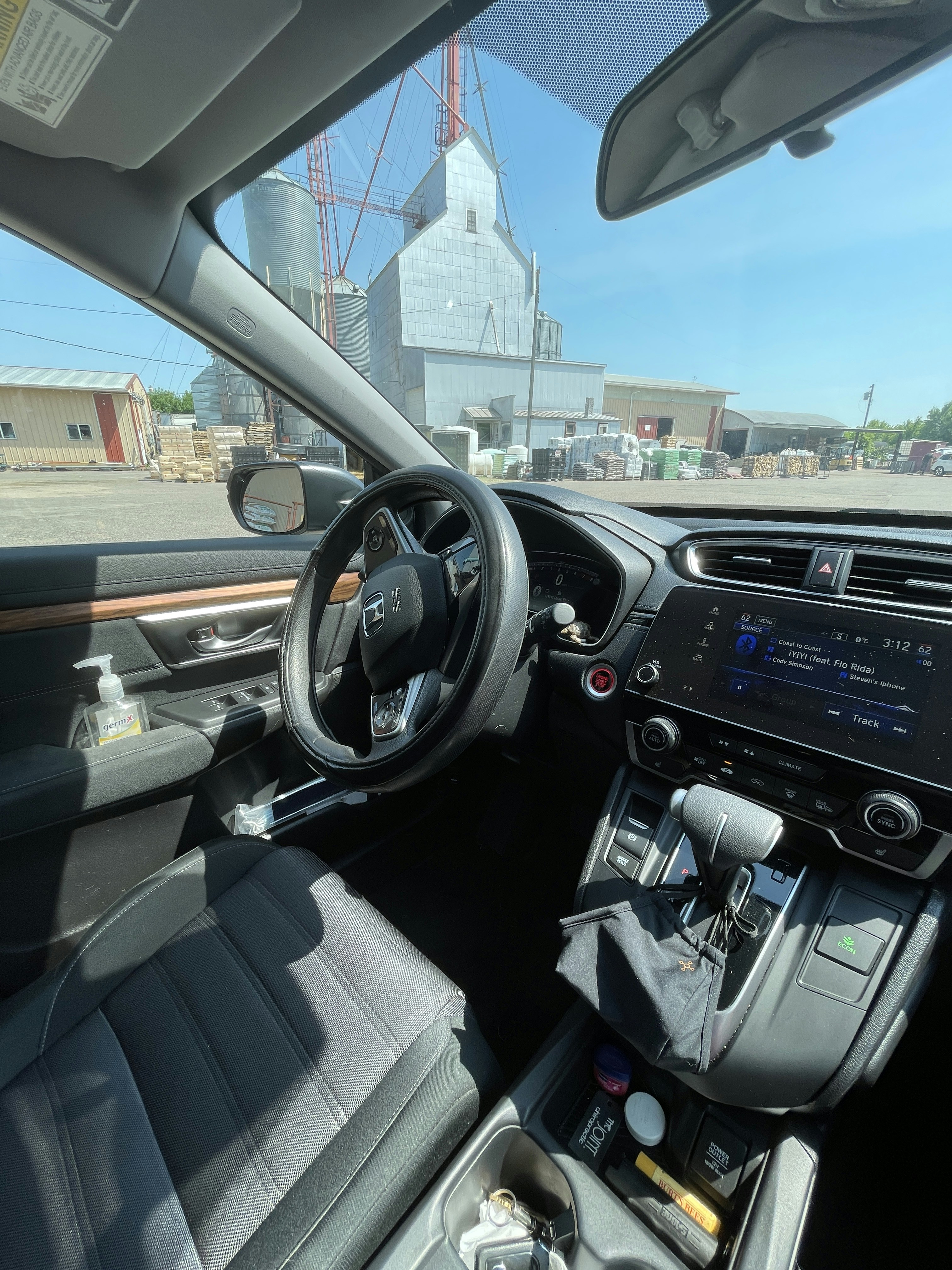 Cockpit in Focus: Sunlit Honda Sedan Framed by Construction Site