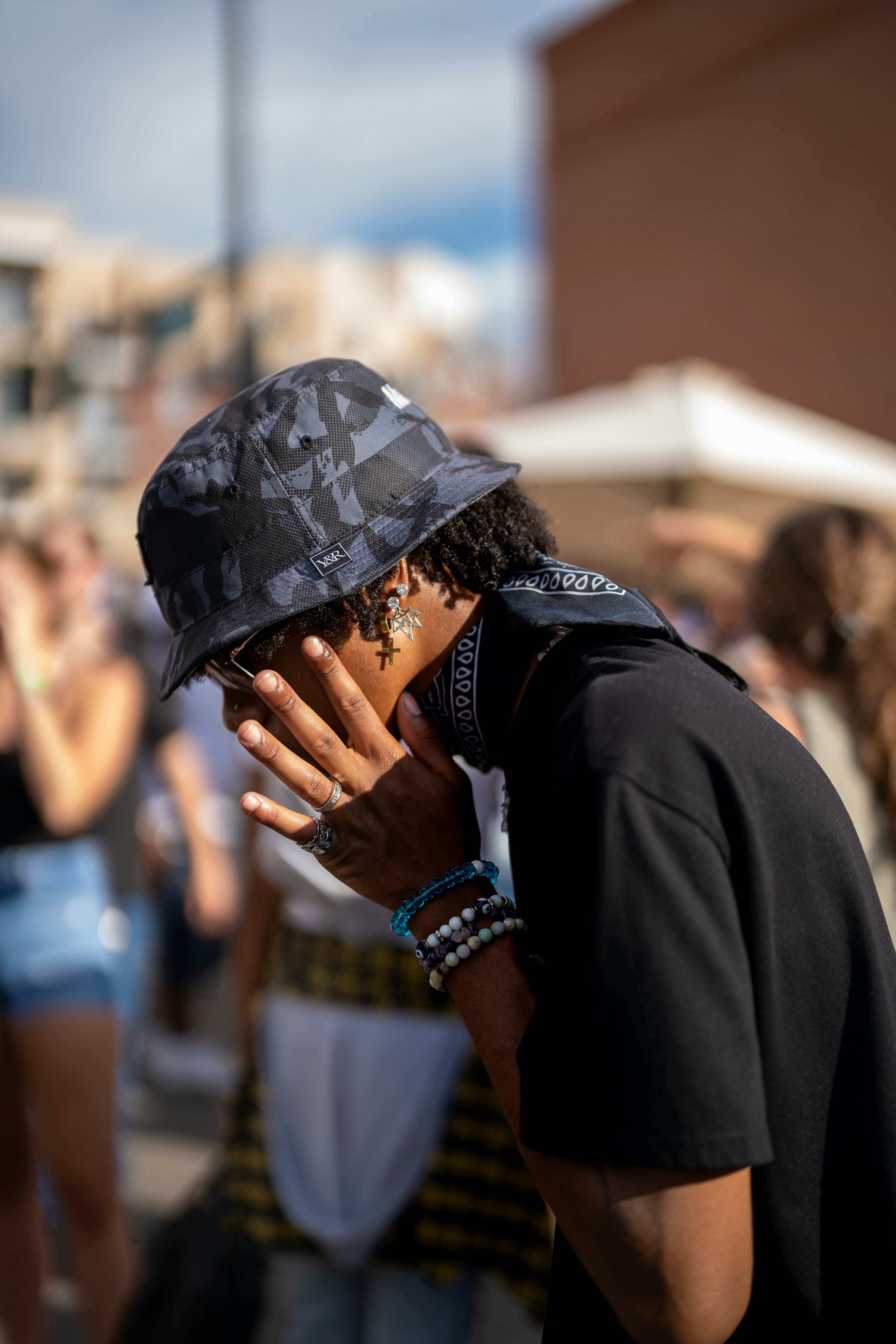 Man in black jacket wearing gray and white camouflage cap covering face ...
