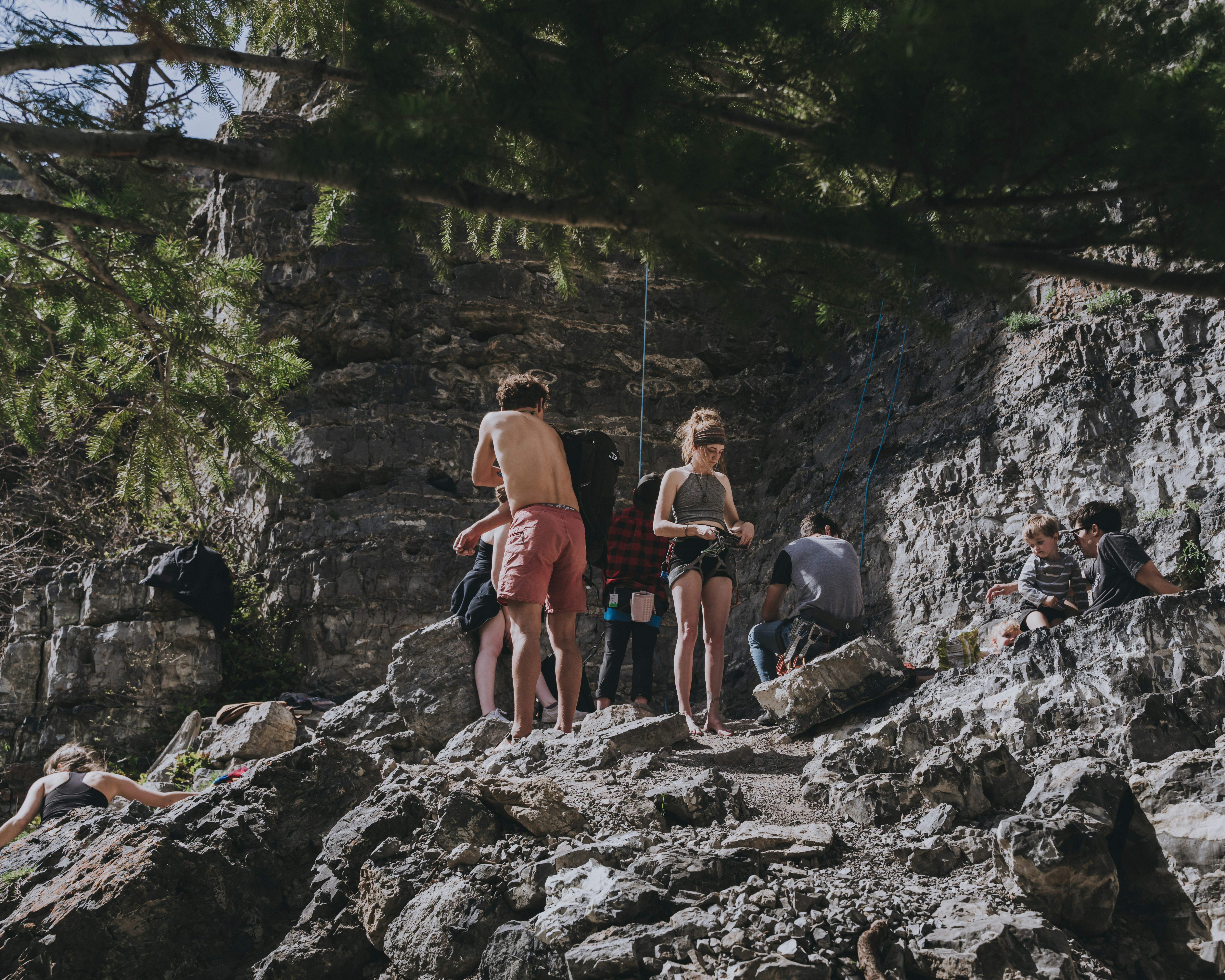 Group of climbers preparing for ascent on rocky terrain, surrounded by nature's rugged beauty. The scene captures the spirit of adventure and camaraderie.