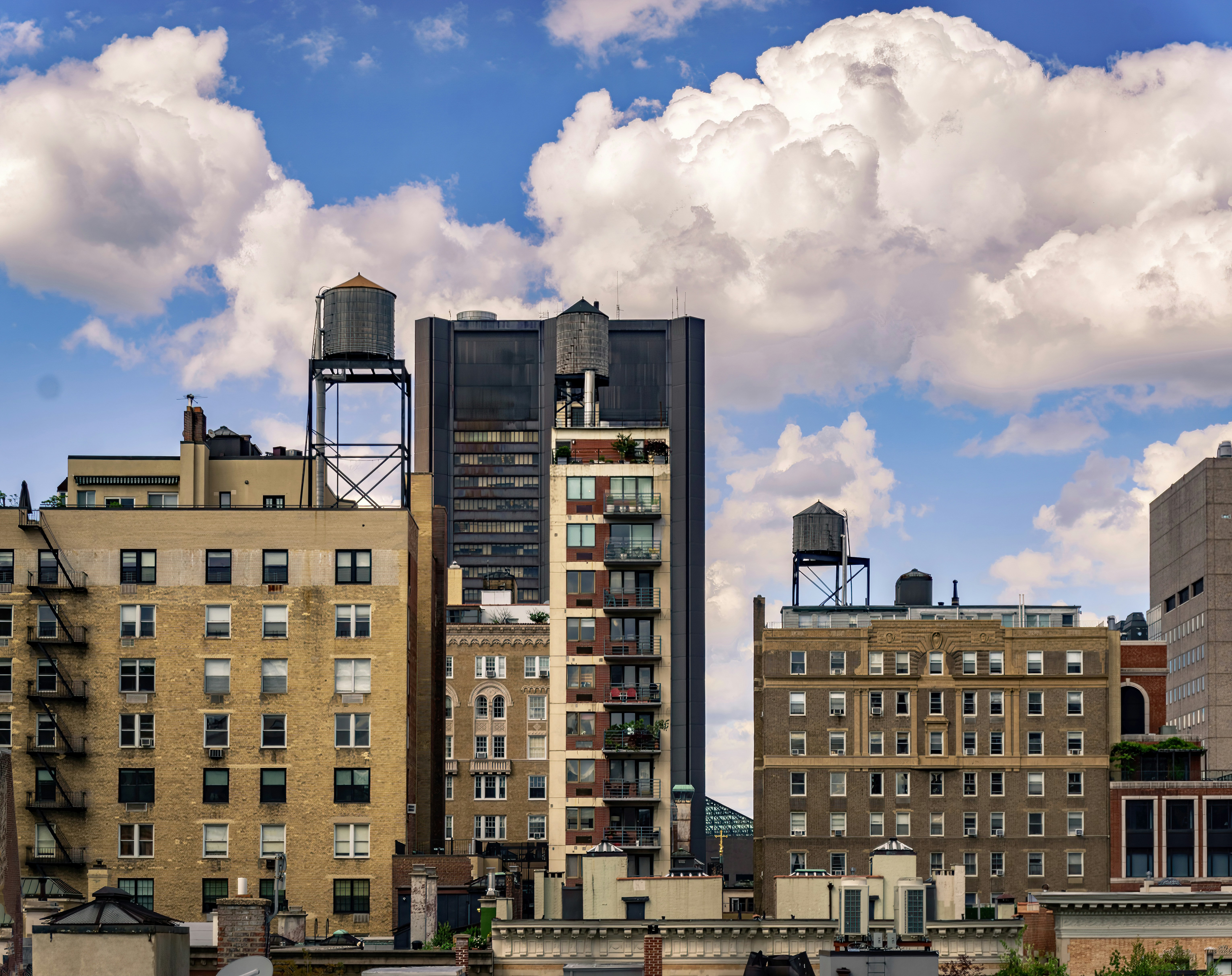 Brown concrete building under white clouds and blue sky during daytime ...