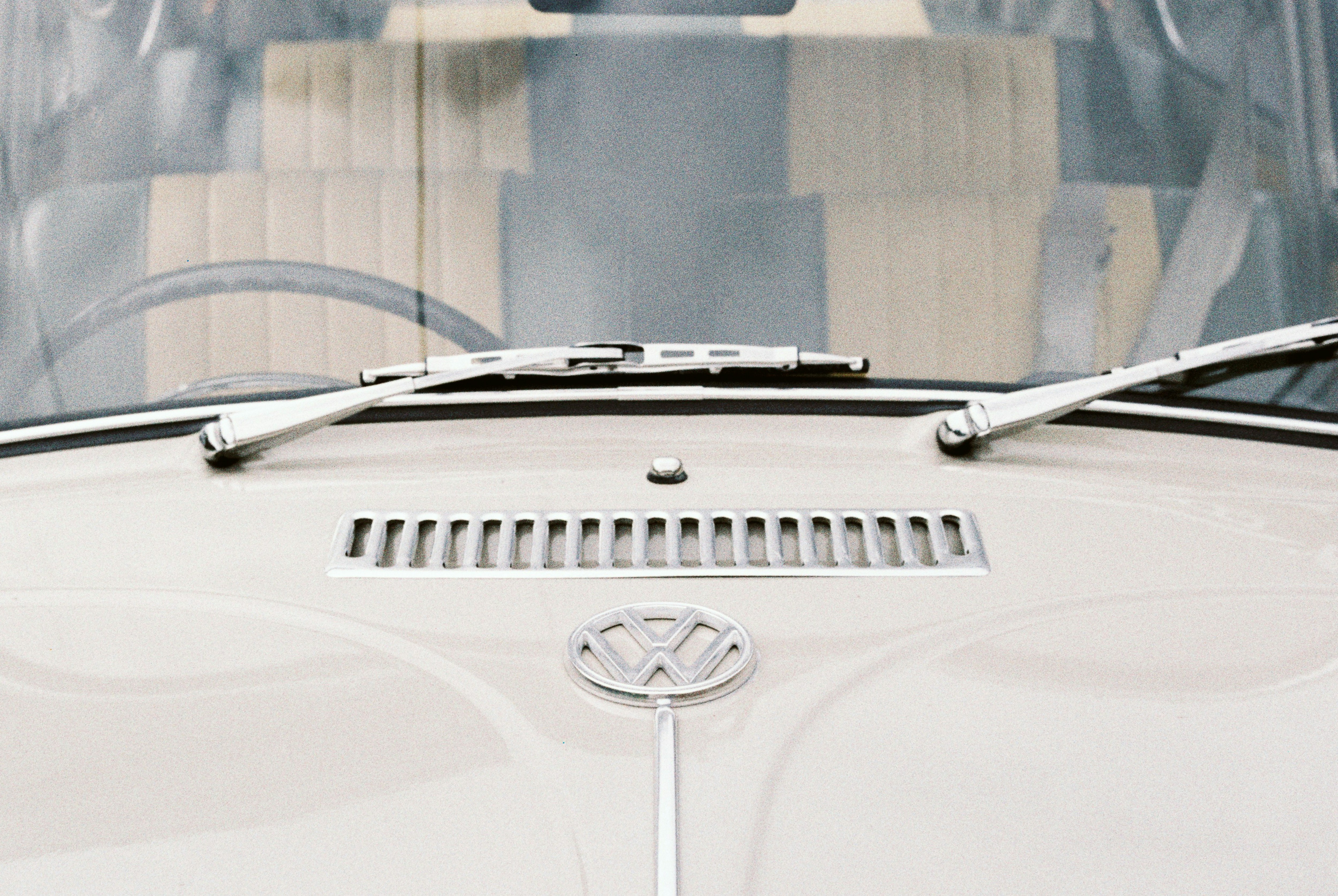 Center-Stage VW Emblem on a Pale Vintage Hood: A Quiet Auto Portrait