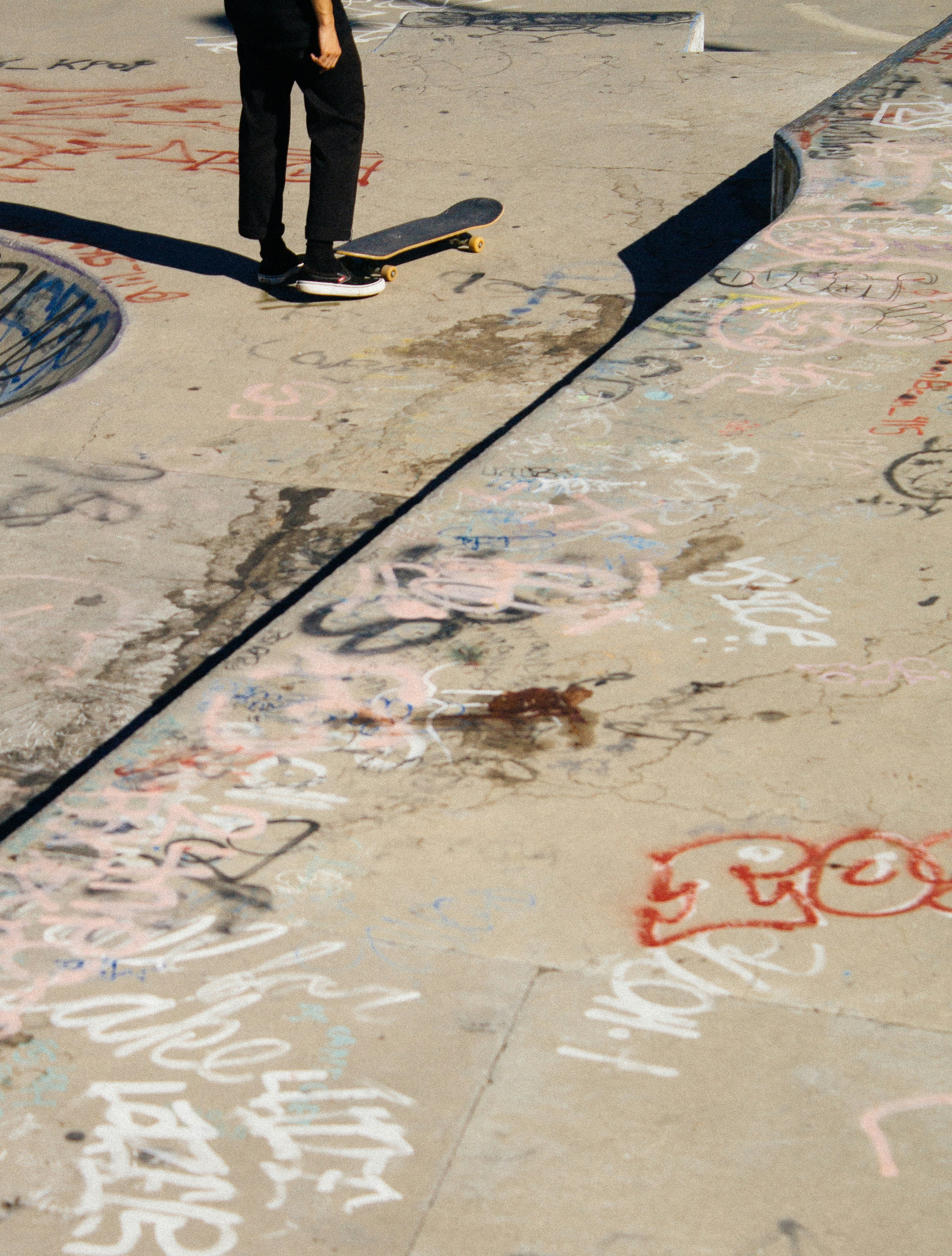 person in black pants walking on gray concrete floor