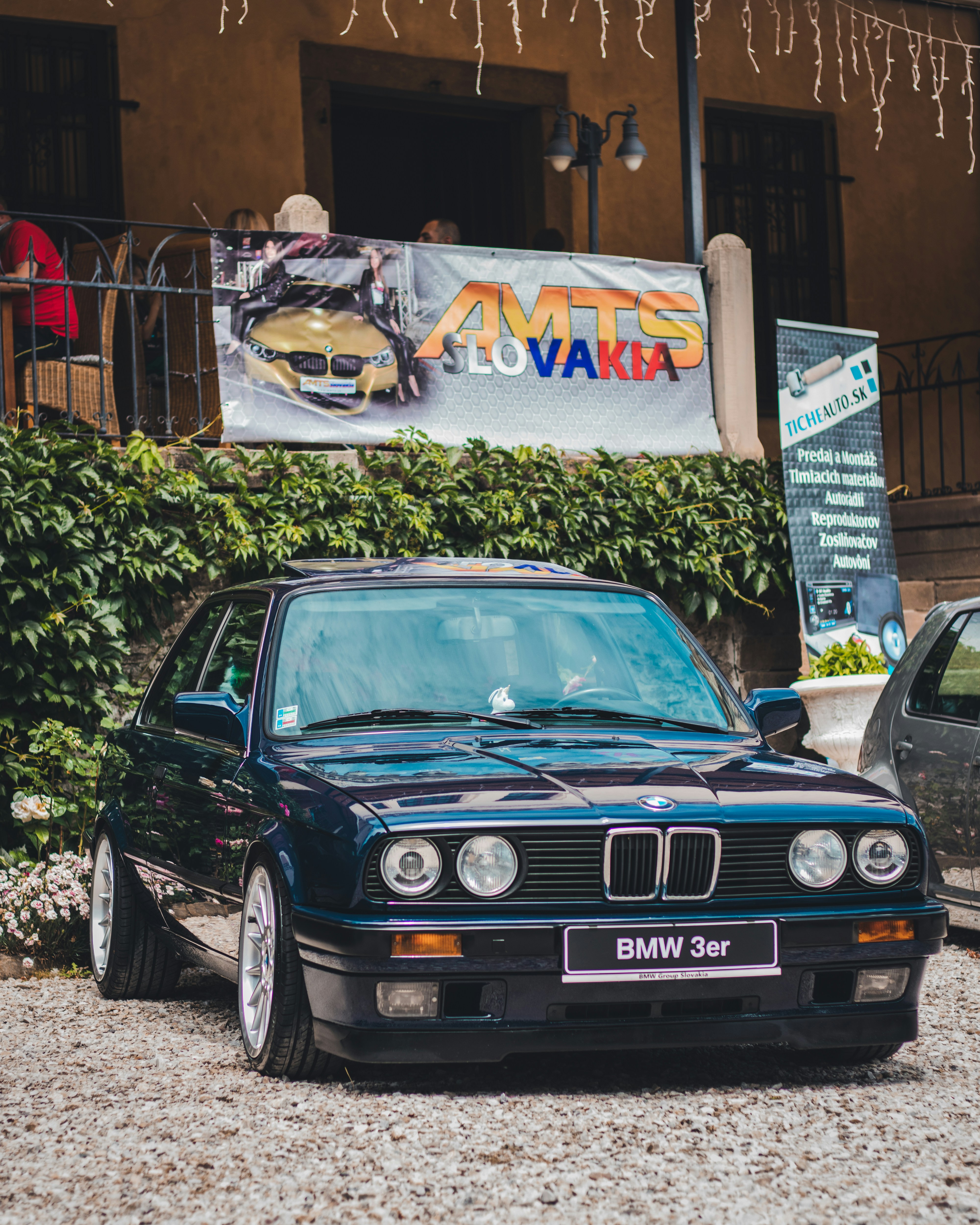 blue bmw m 3 parked near white and blue concrete building during daytime