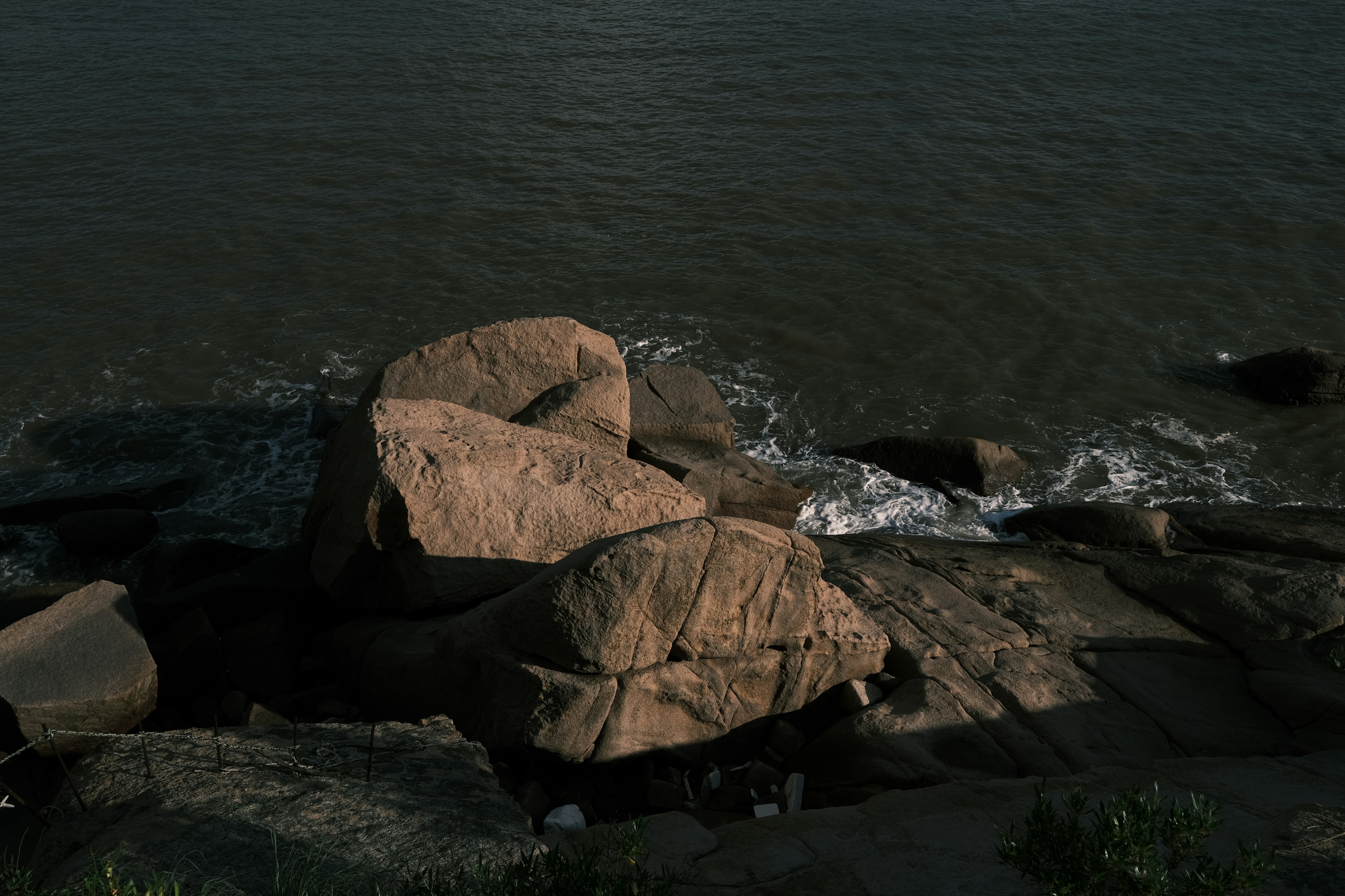 brown rock formation beside body of water during daytime