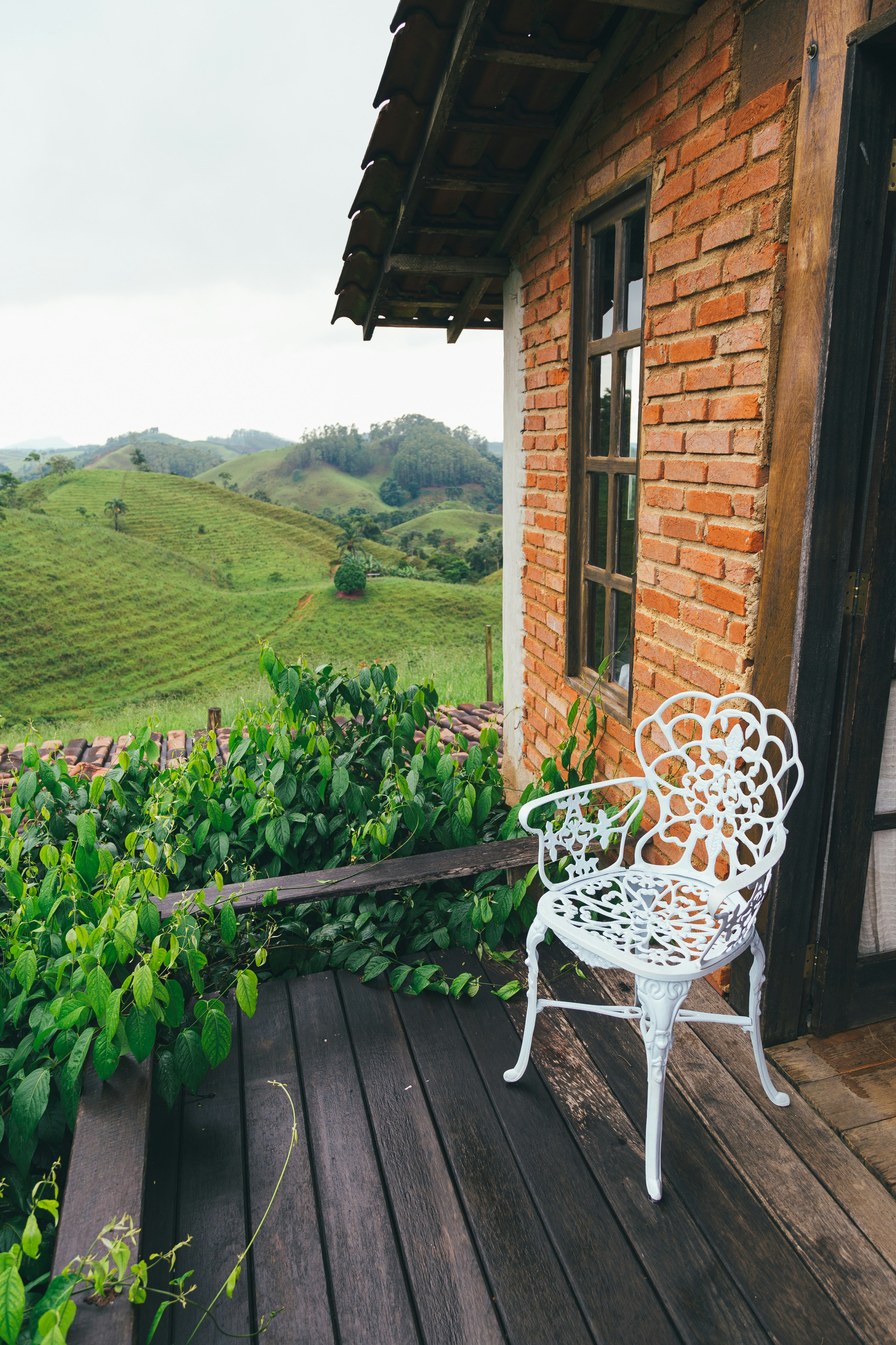 Terraced Hillside View from a Brick Terrace With Ornate White Chair