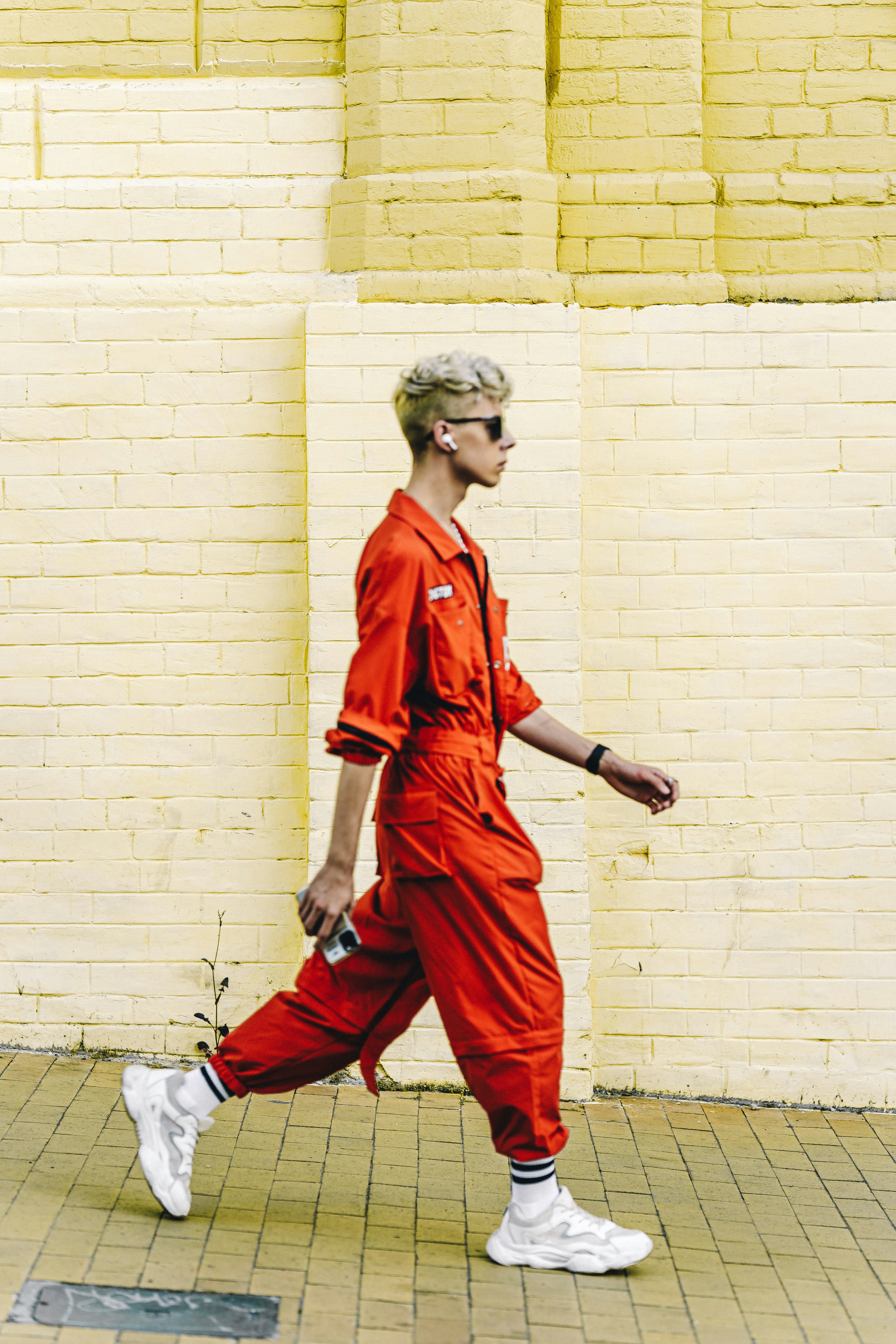 Boy in red long sleeve shirt and red pants walking on sidewalk during ...