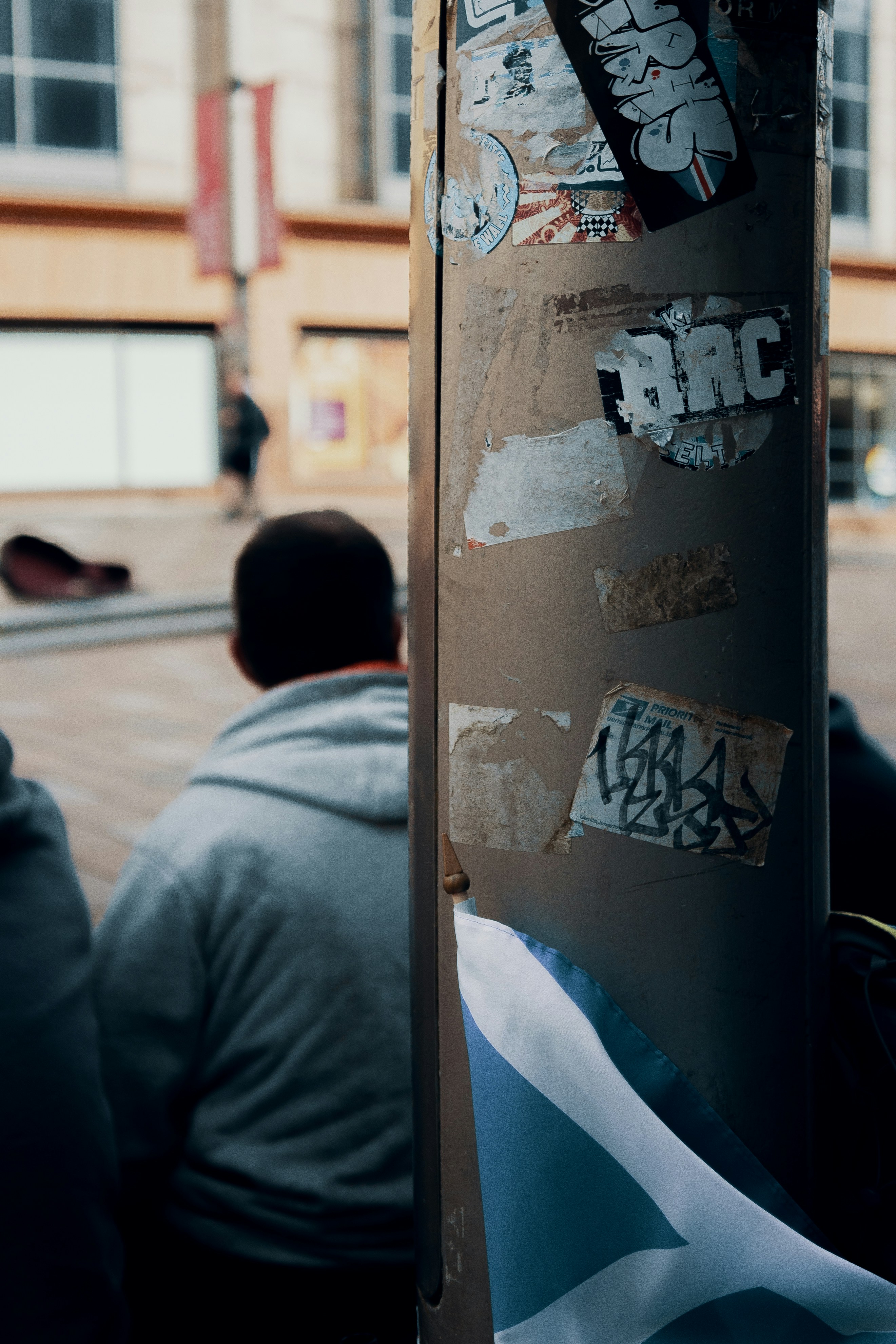 Weathered Street Column: Stickered Pillar in Busy Urban Quiet
