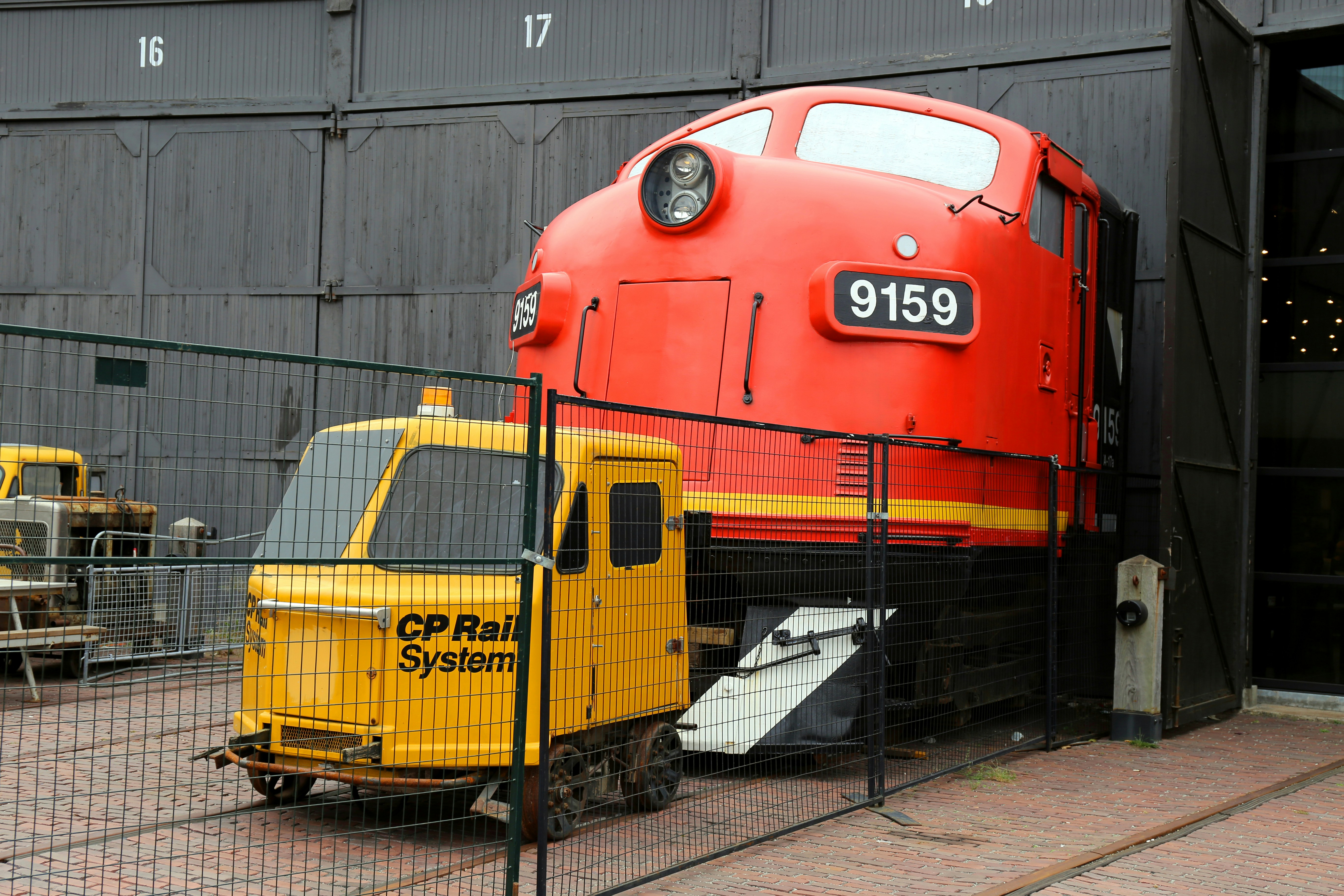 Gleaming Red Locomotive Watching Over a Yellow Work Railcar