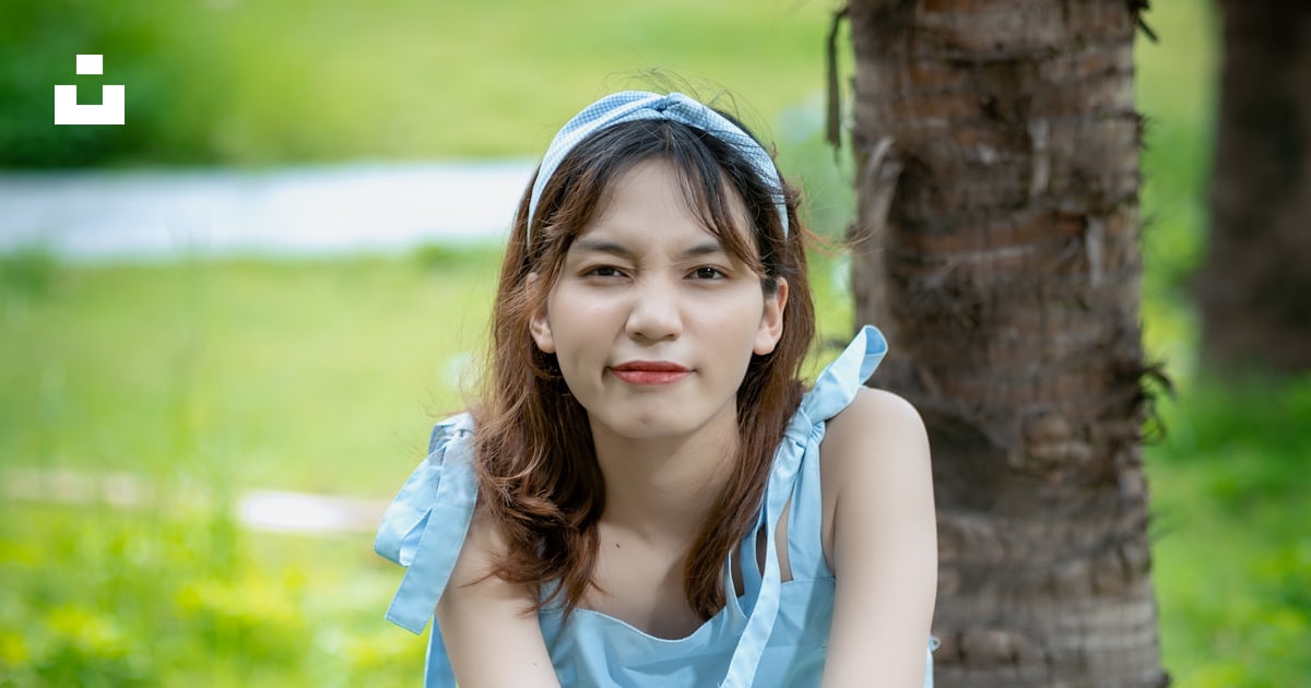 푸른 잔디밭에 앉아 있는 하얀 민소매 드레스를 입은 소녀 사진 Unsplash의 무료 야외 이미지