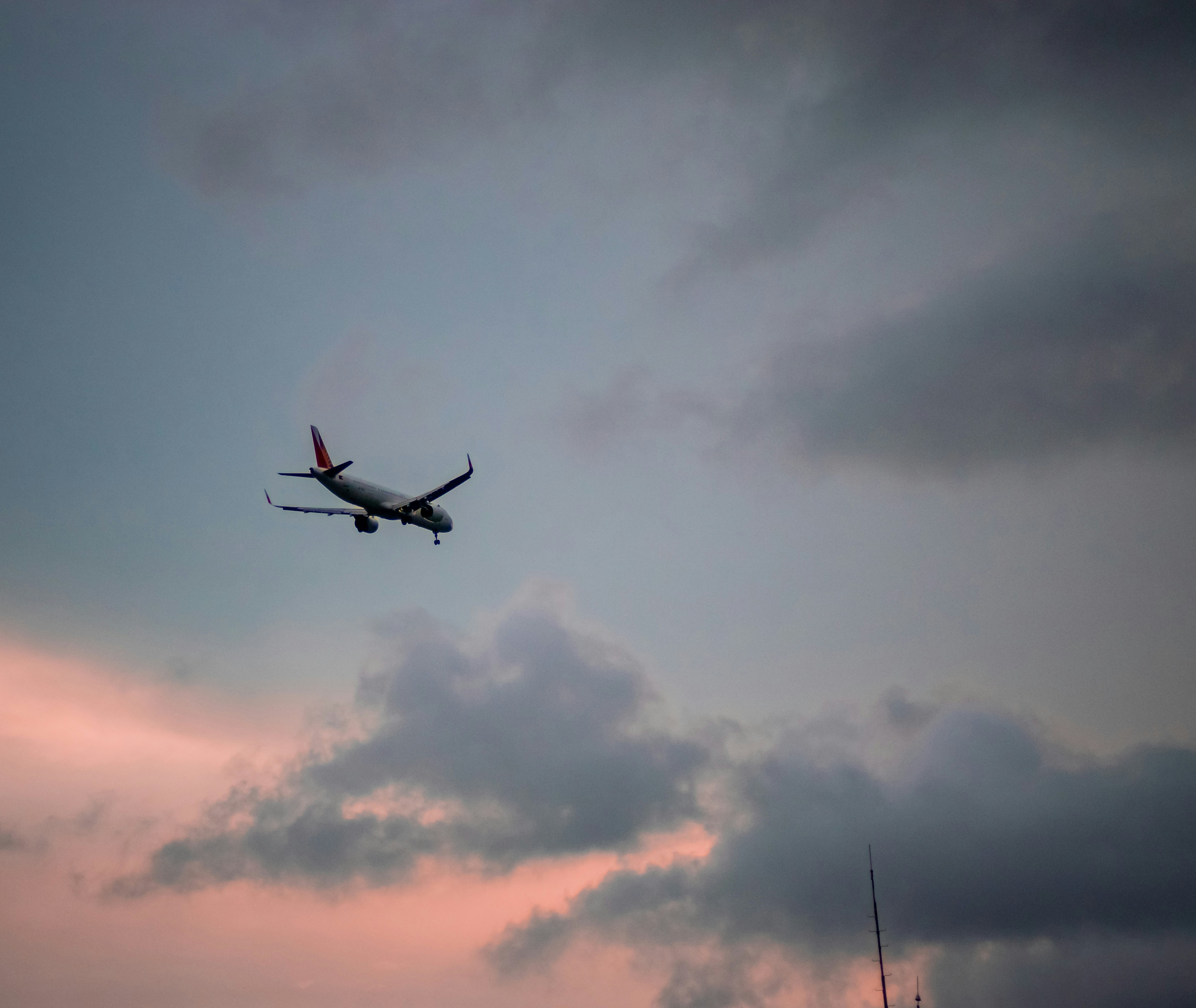 White and red airplane flying under cloudy sky during daytime photo ...