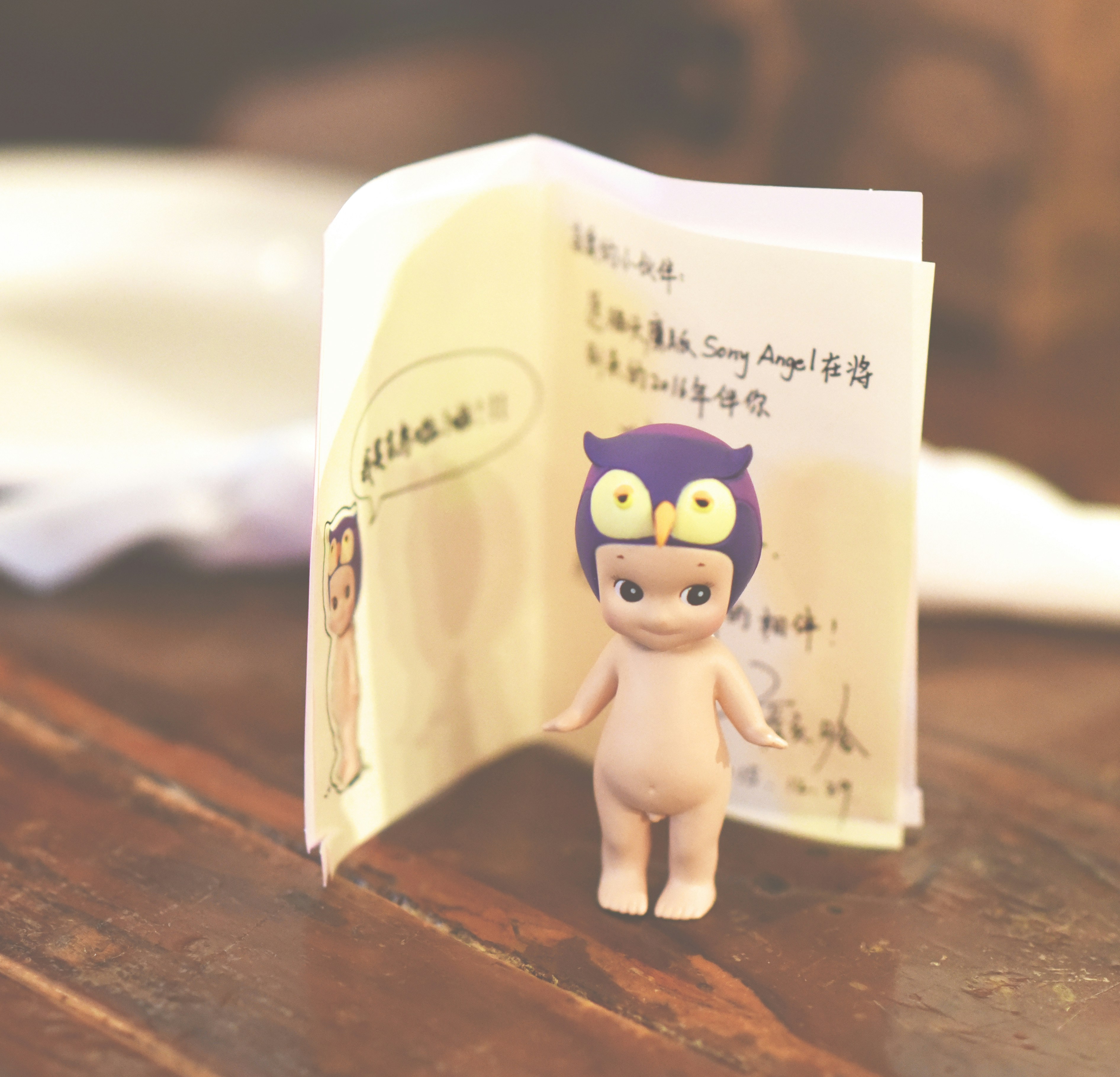 The Page-Turner: A Tiny Owl-Hooded Figurine Anchors a Book-Page Theater