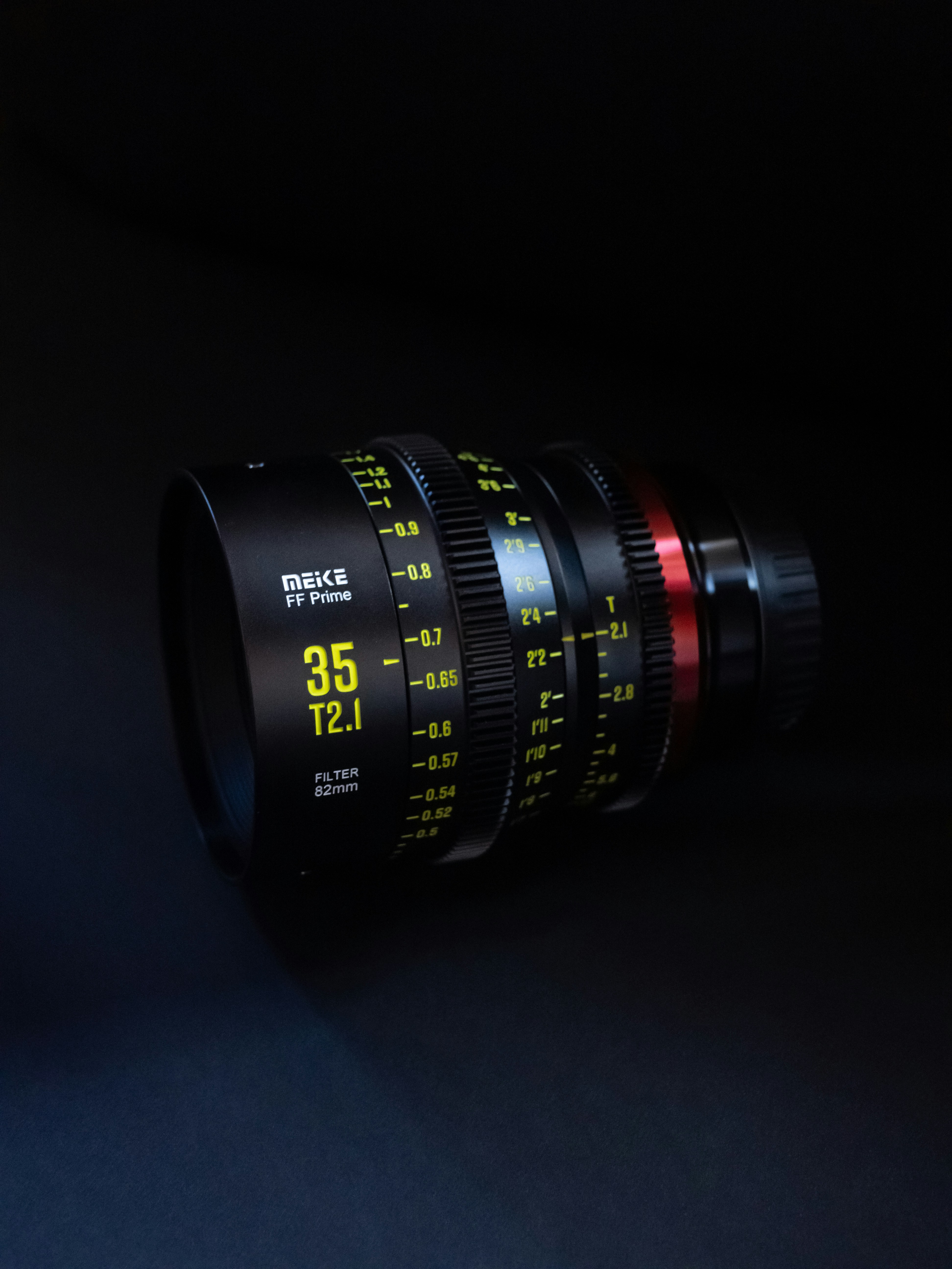 Close-up of a Meike FF Prime 35mm T2.1 lens showcasing its detailed markings and design against a dark background.
