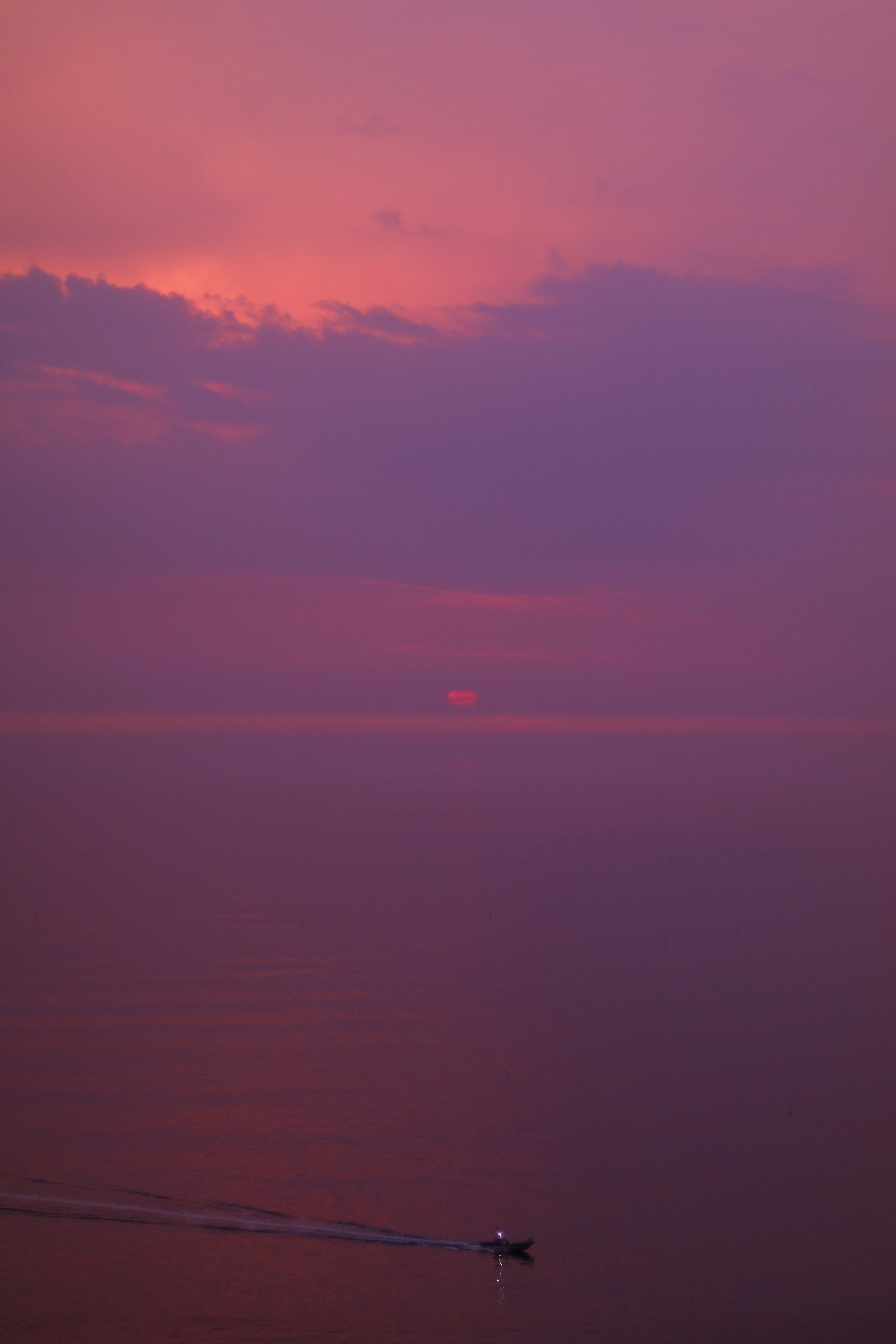 Silky Purple Horizon: A Distant Boat Beneath a Quiet Sunset
