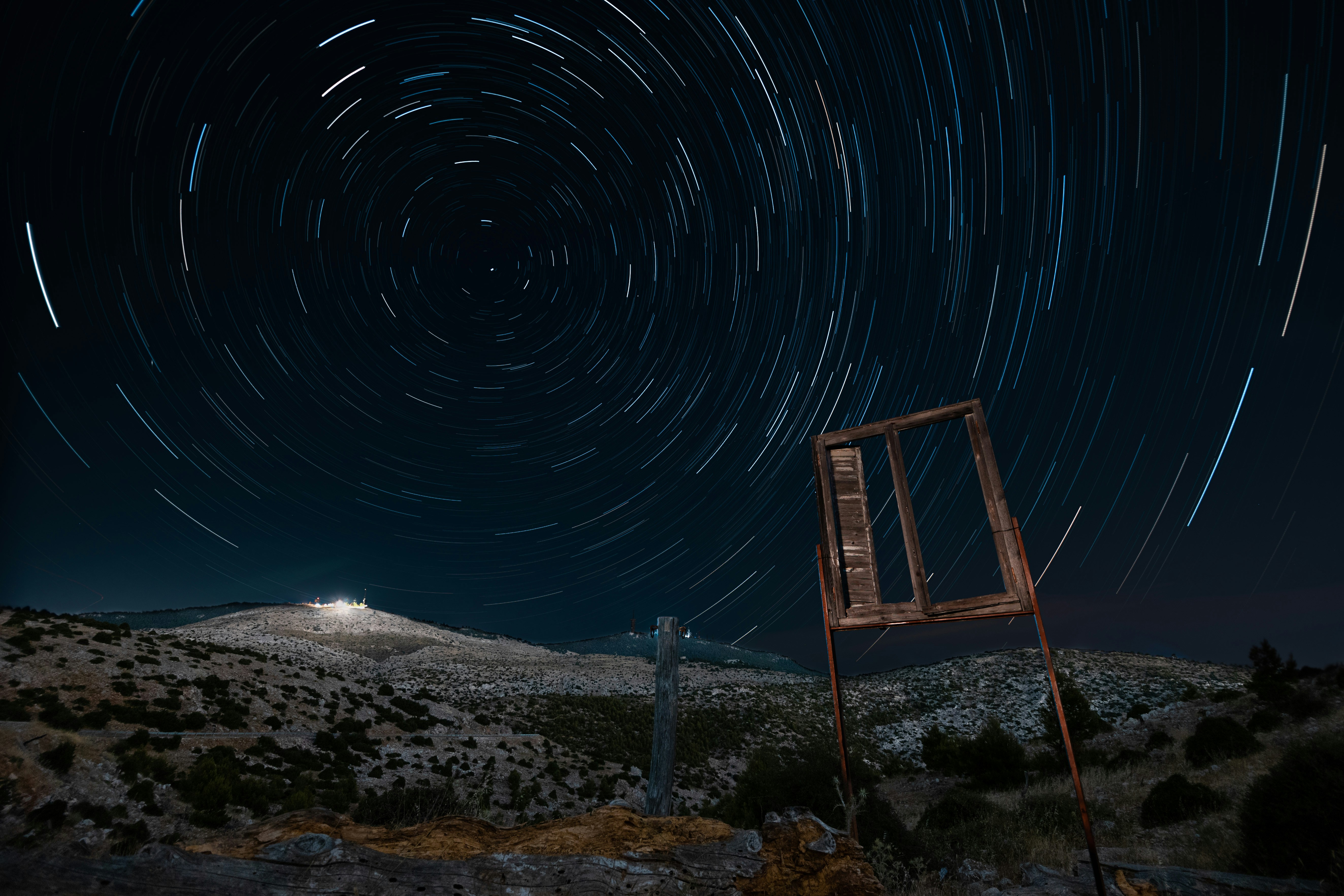 Whirl of Stars Over a Tilted Rust Frame in a Desert Night