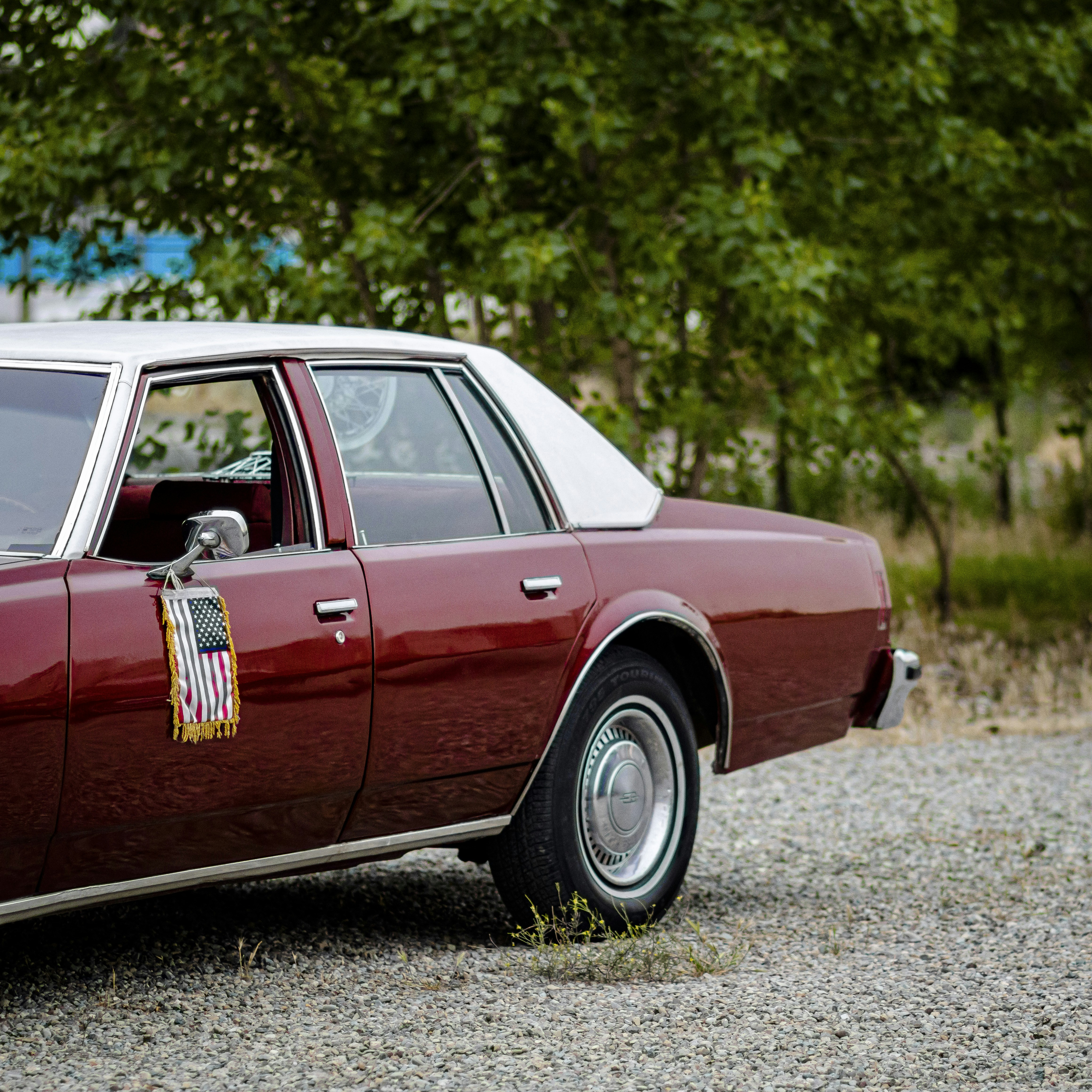 Mid-century maroon cruiser parked on a gravel overlook