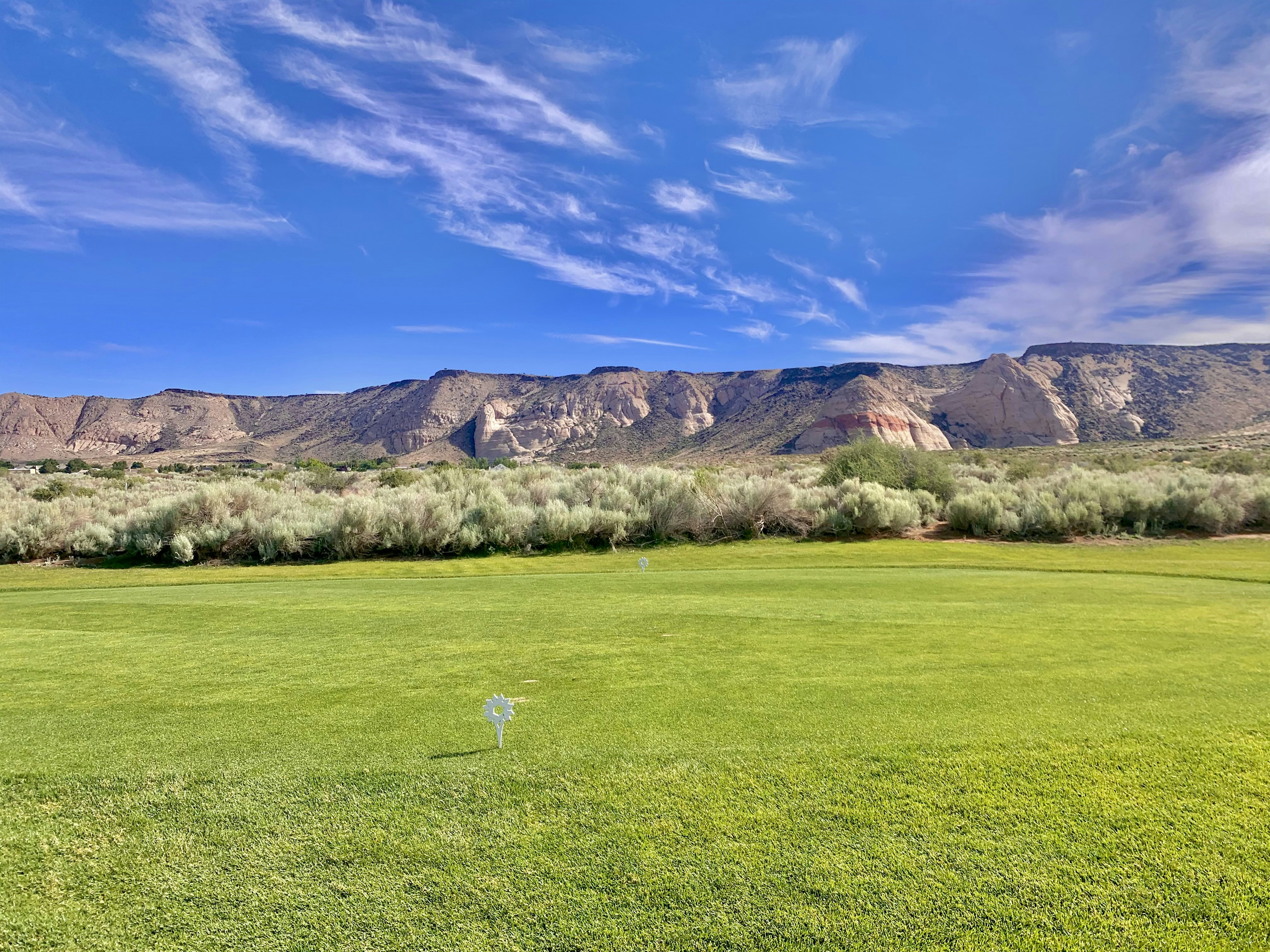 Green grass field near brown mountain under blue sky during daytime ...