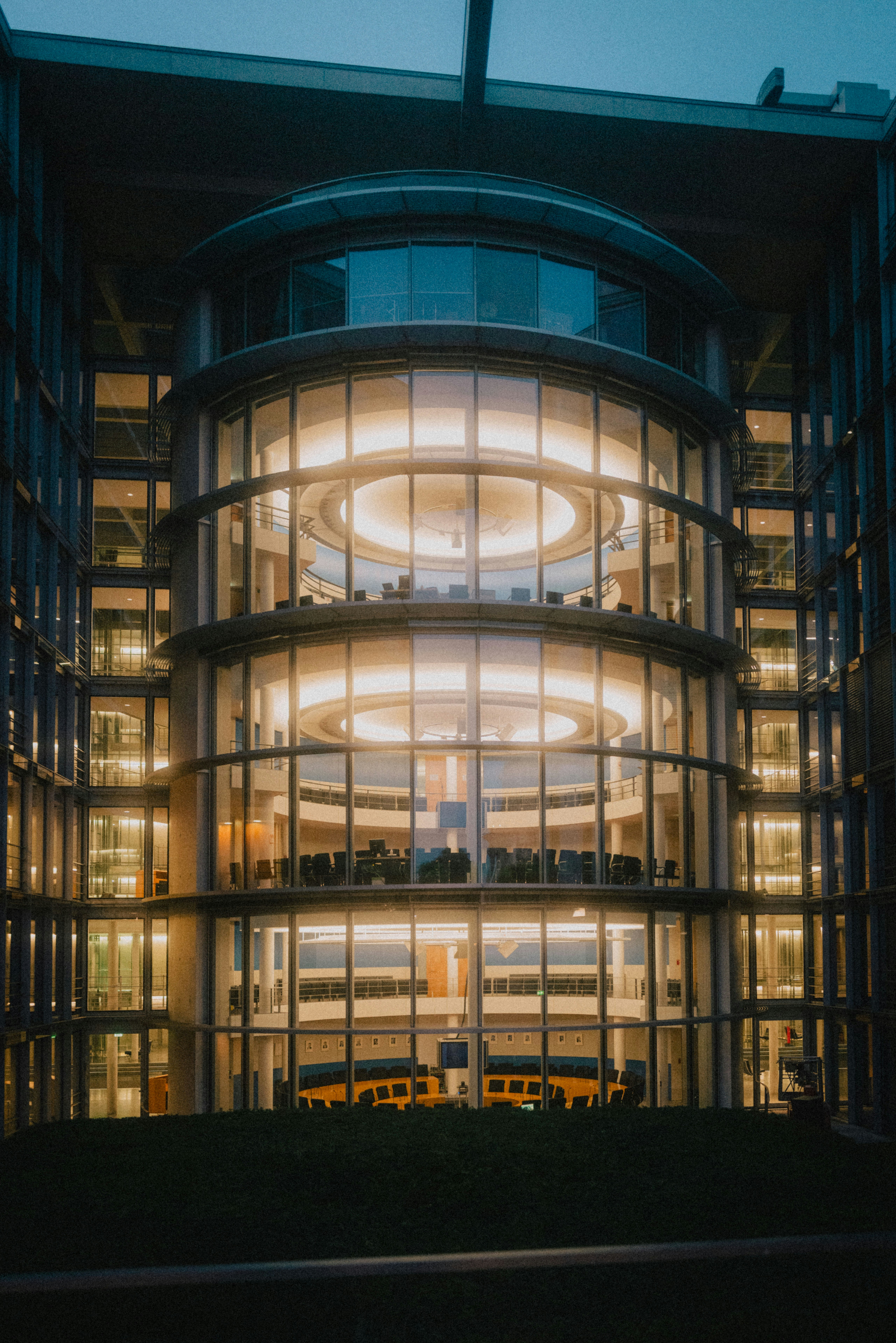 Halo Rings of Light Encircle a Nighttime Glass Atrium