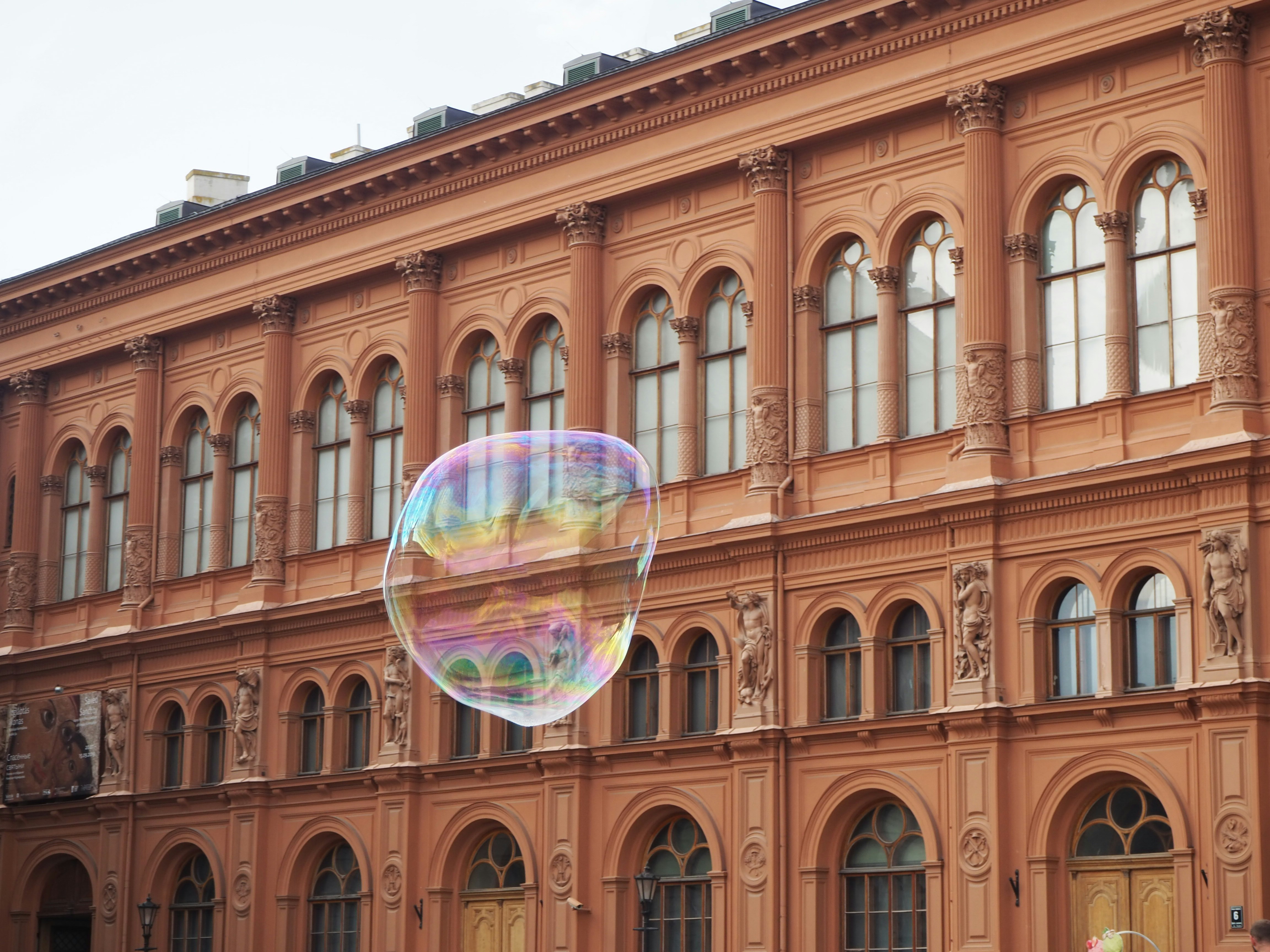 Bubble floating on mid air near brown concrete building during daytime ...