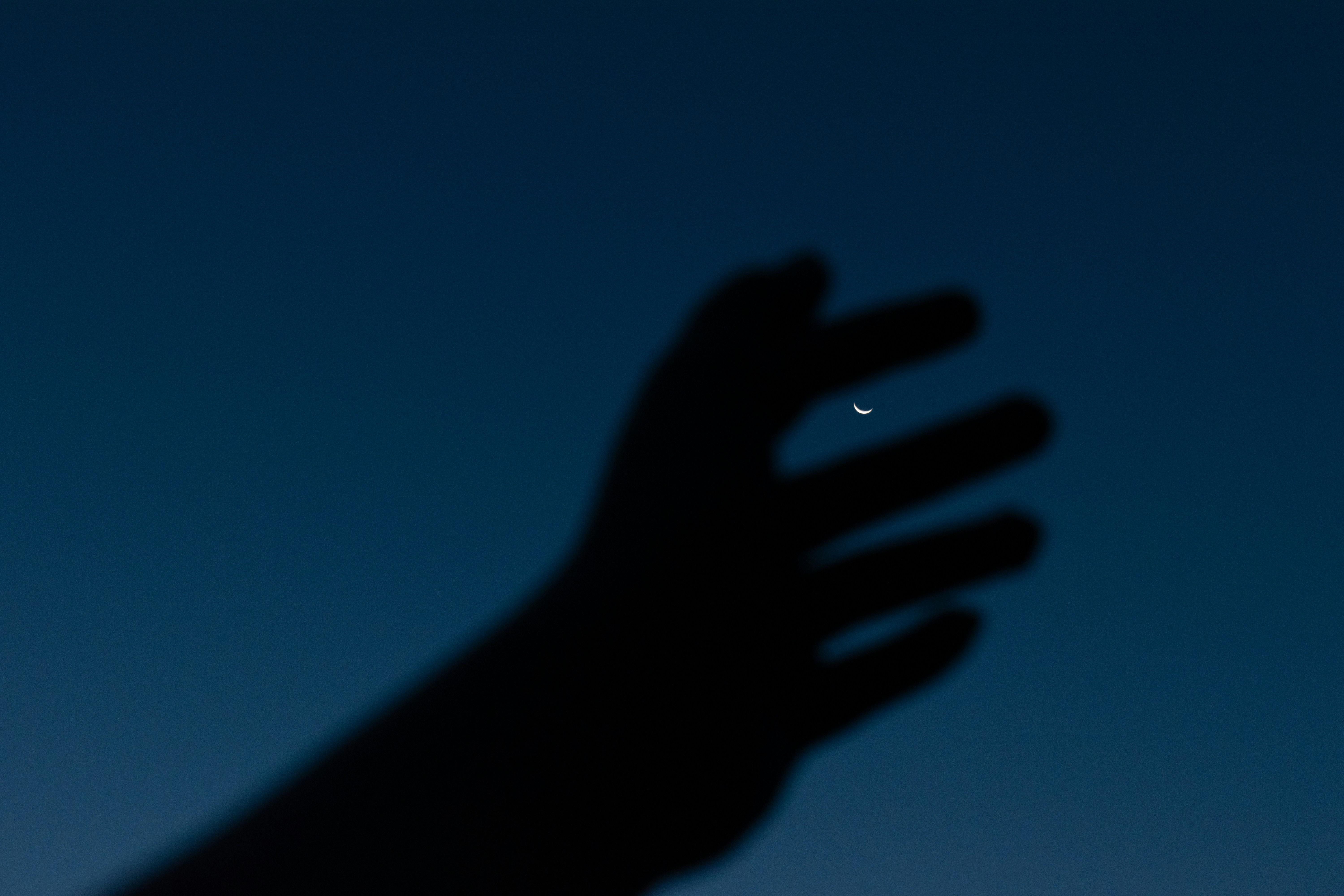 persons left hand with blue background