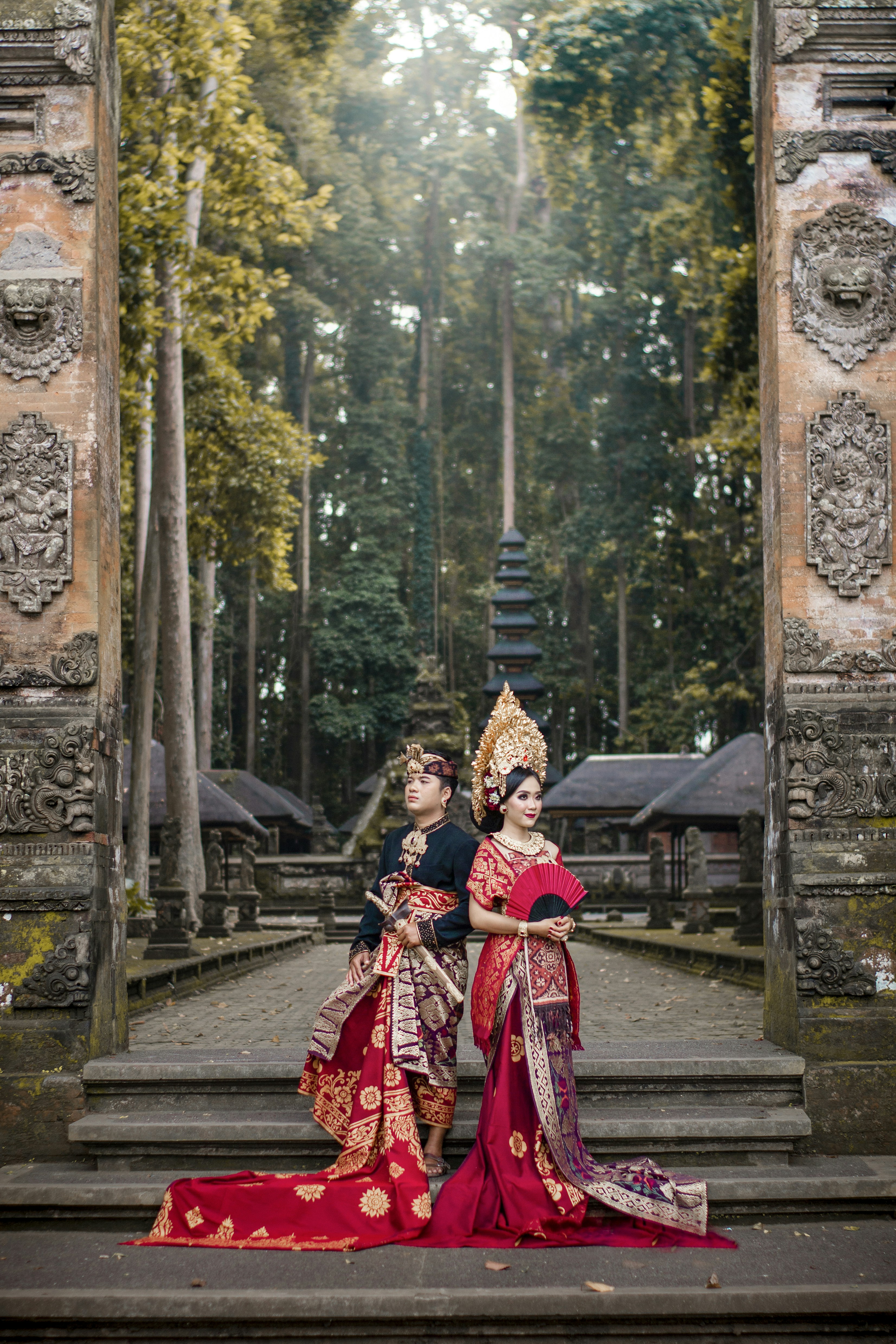 Red Silk at the Gate: A Regal Duo Beneath an Ancient Temple Arch