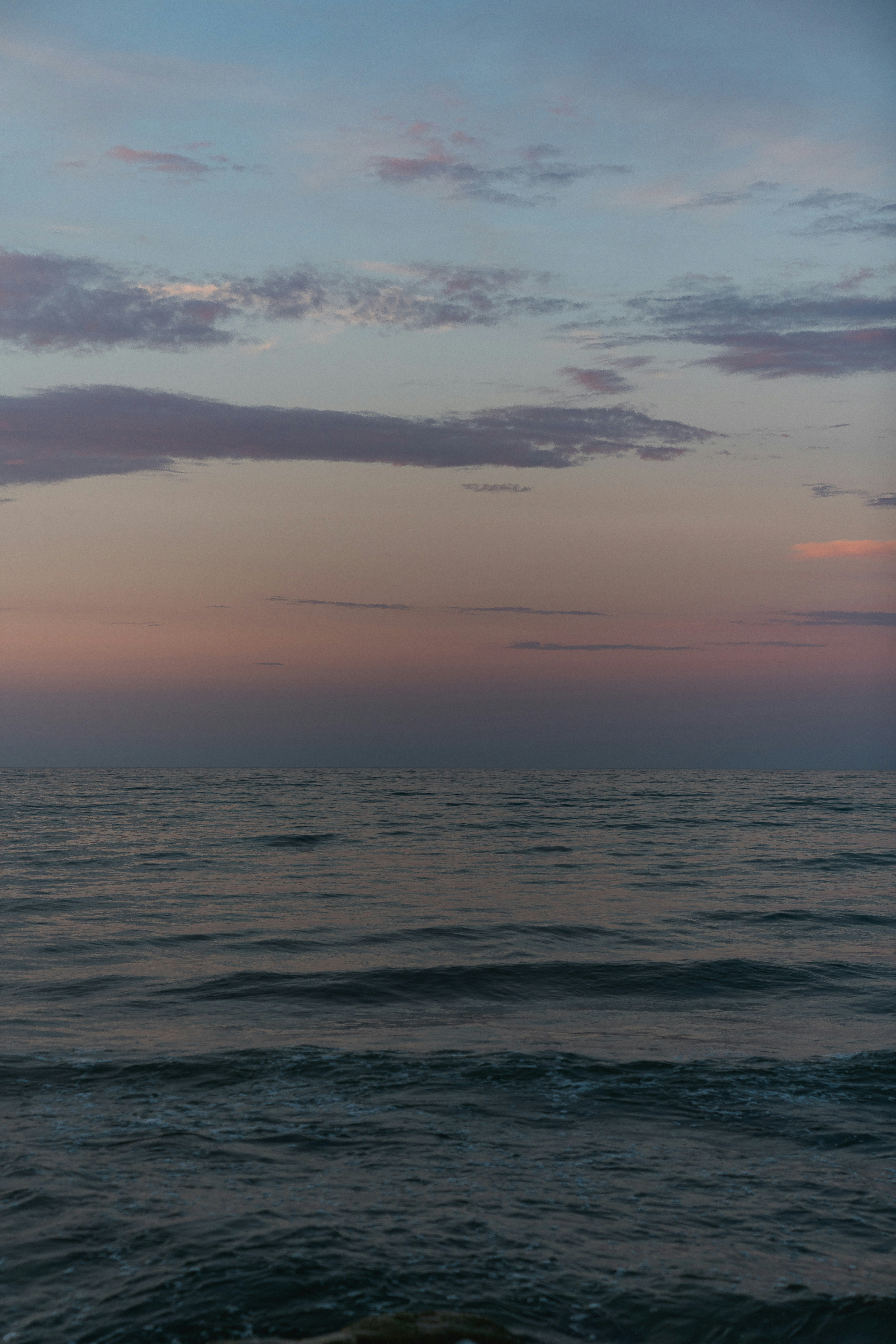 Gentle waves beneath a pastel sky at dusk.