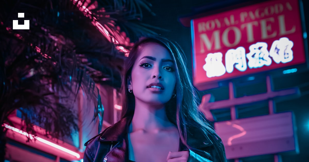 夜間、赤と白のネオン看板のそばに立つ黒い革ジャンを着た女性の写真 Unsplashの写真術の無料画像
