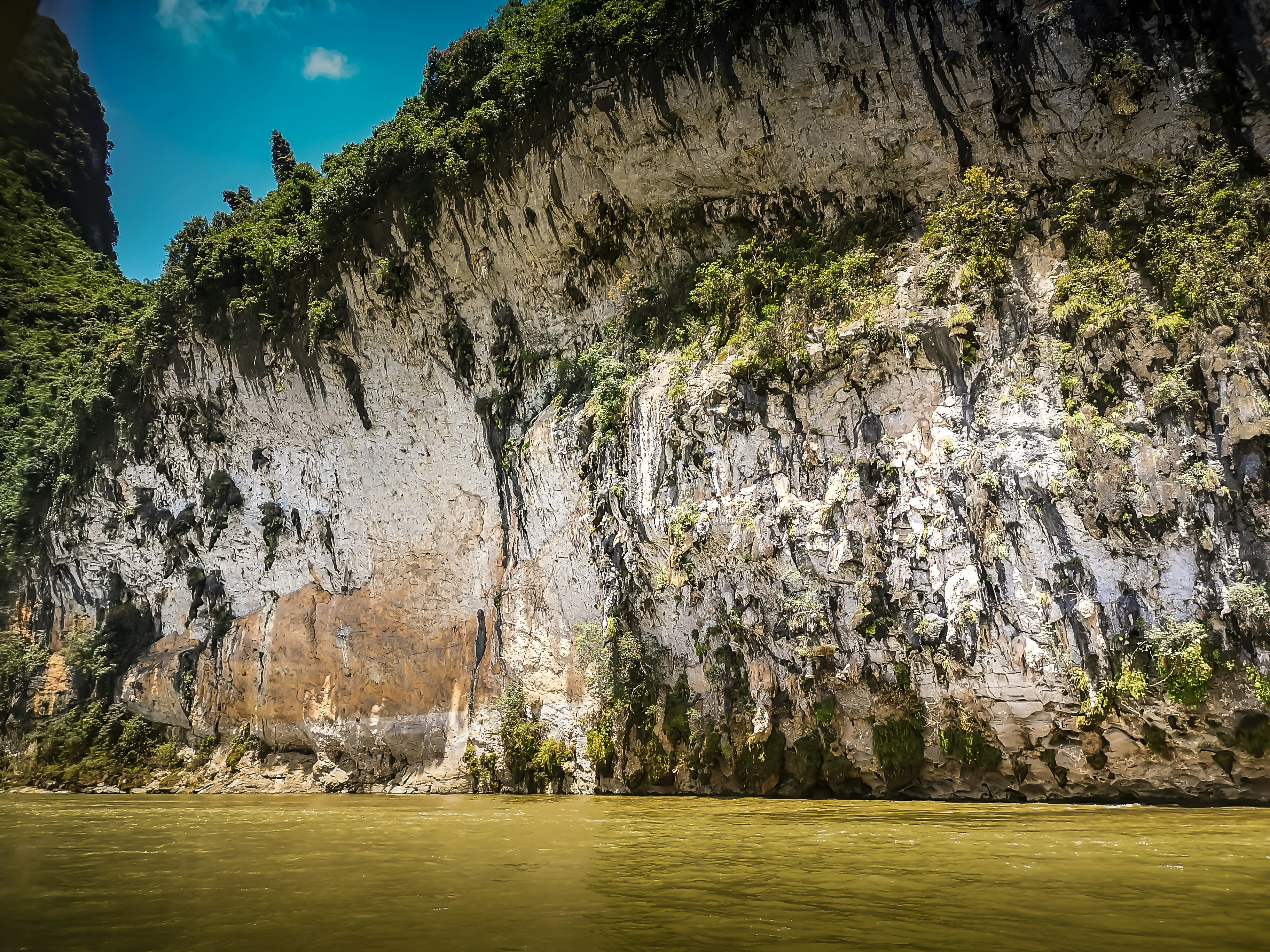 Gray and black rock formation beside body of water during daytime photo ...