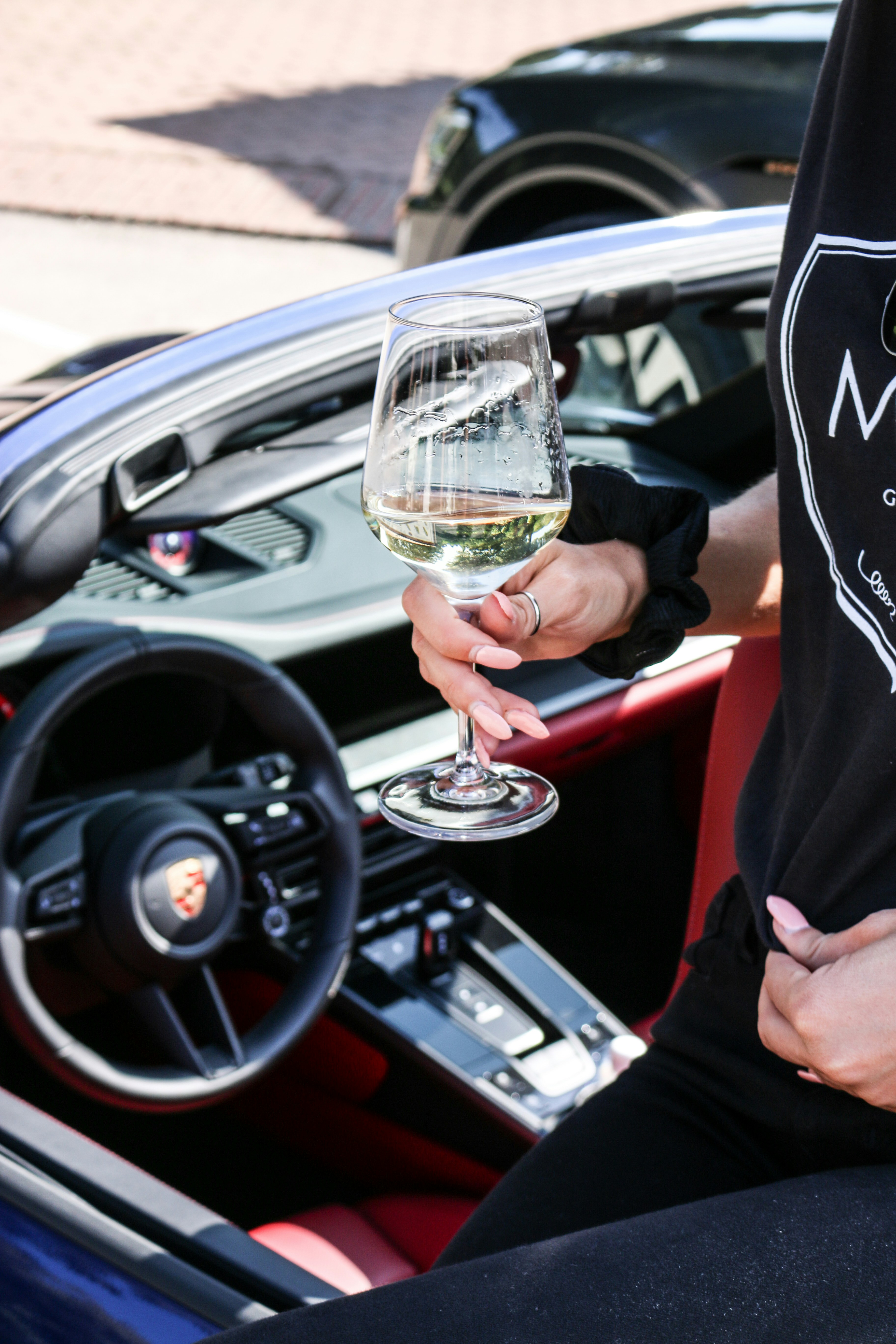 Chardonnay in the Porsche Cockpit: A Quiet Moment Amid Red Leather
