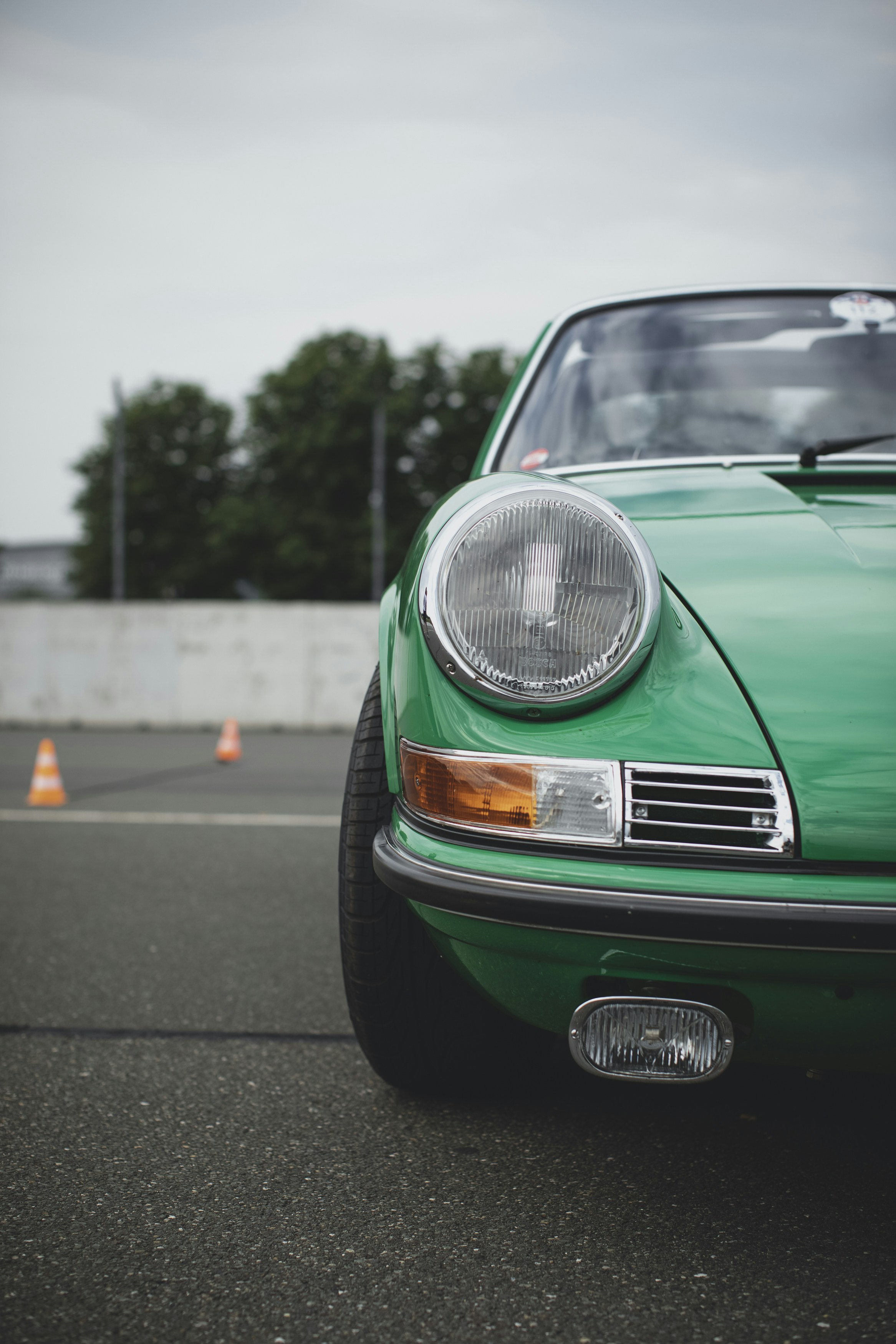 Mint-green Porsche Front: A Vintage Headlight in a Parking-Lot Moment