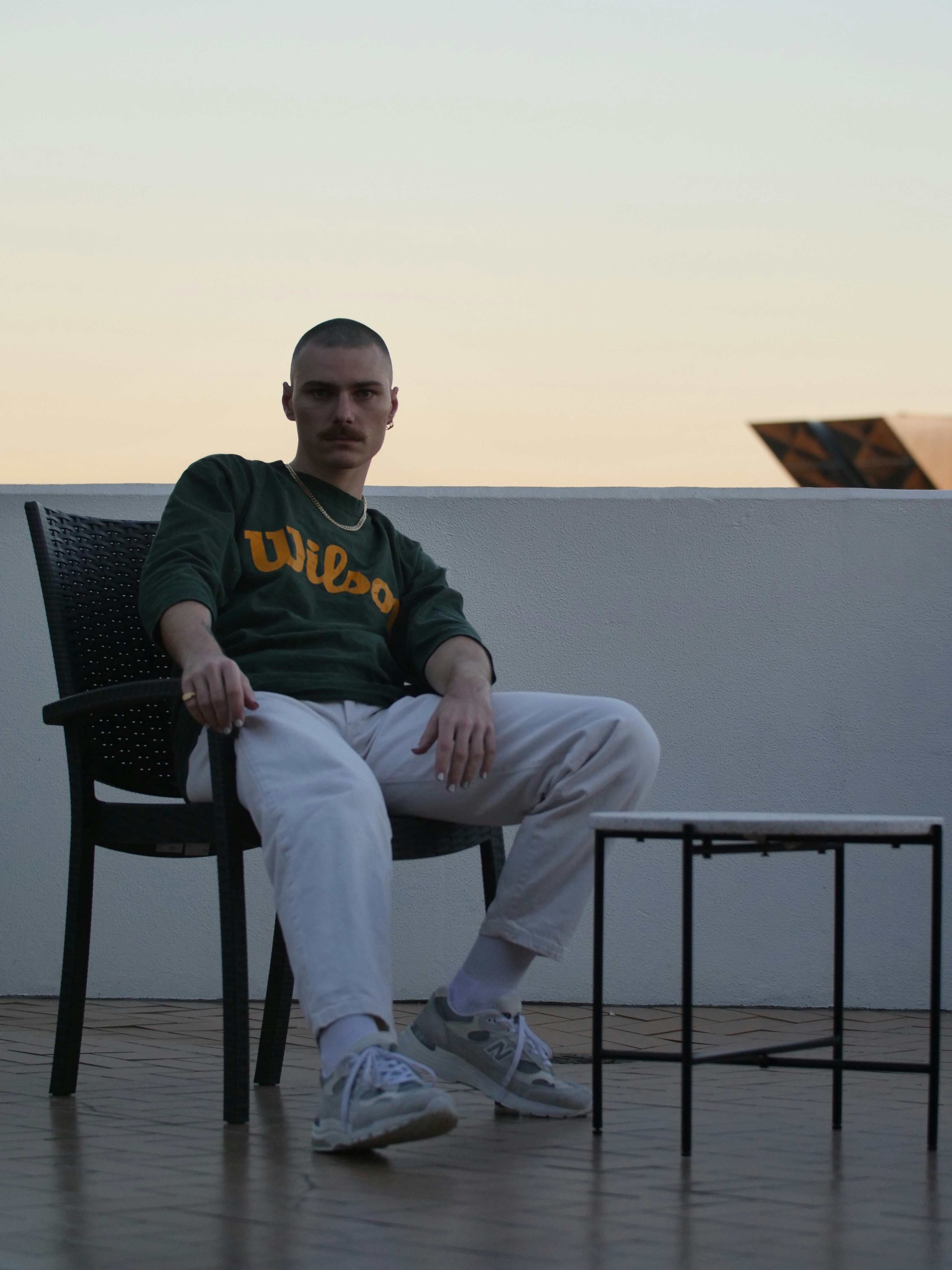 Rooftop Quietude: A Man in Green at Dusk