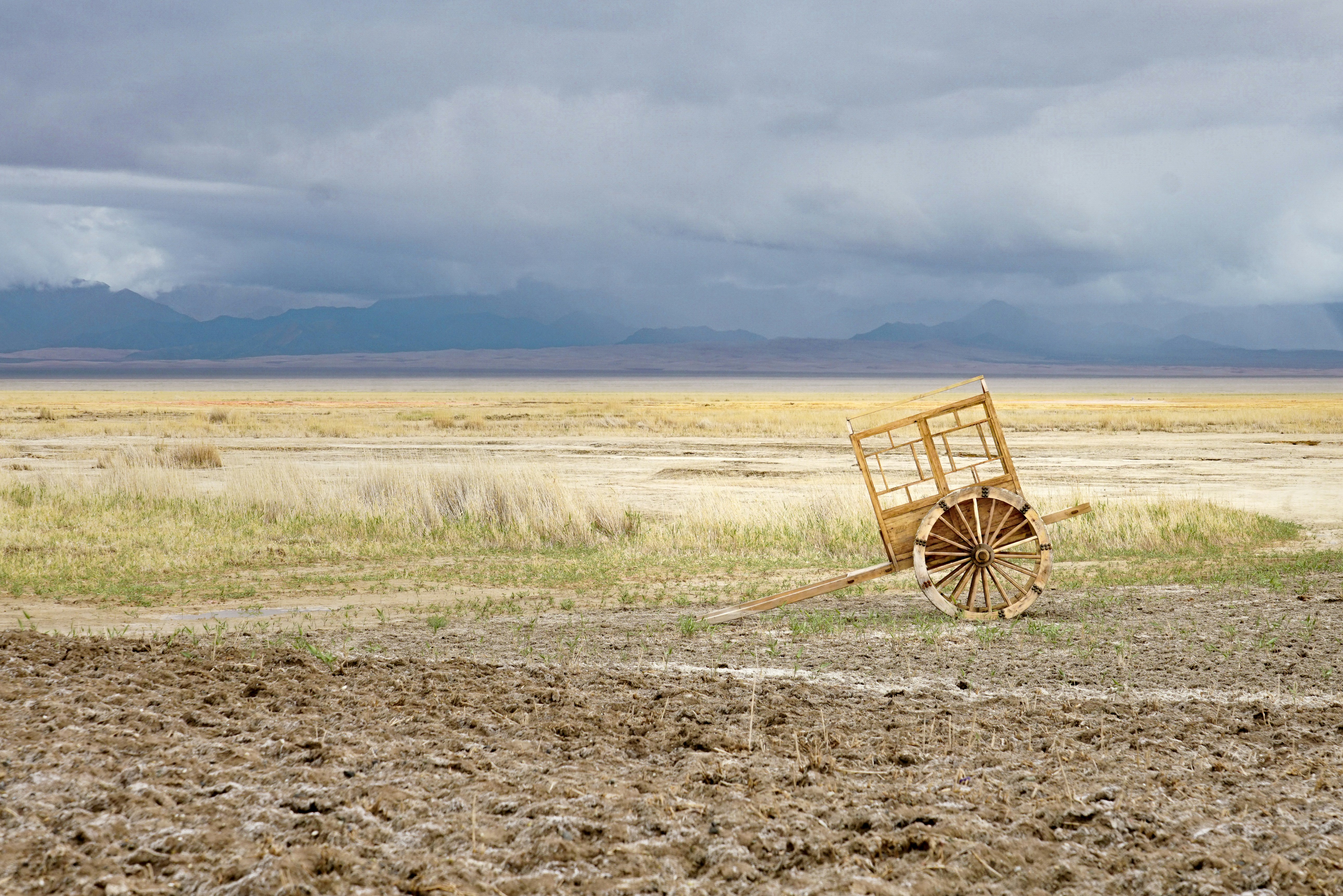 Abandoned Wheel Cart in a Vast Salt Plain under Ruffled Skies