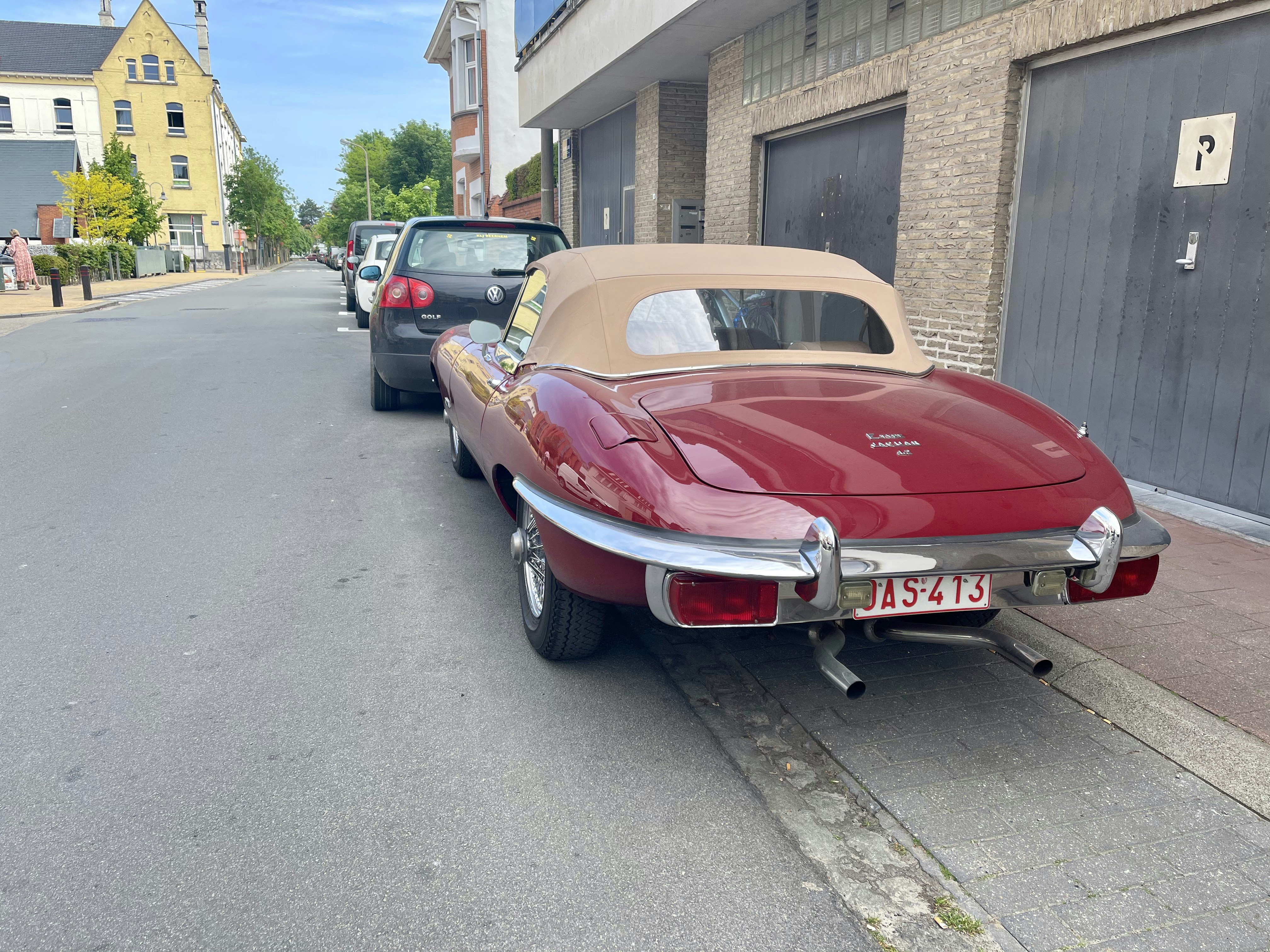 Sunlit Crimson Convertible on a Quiet City Street